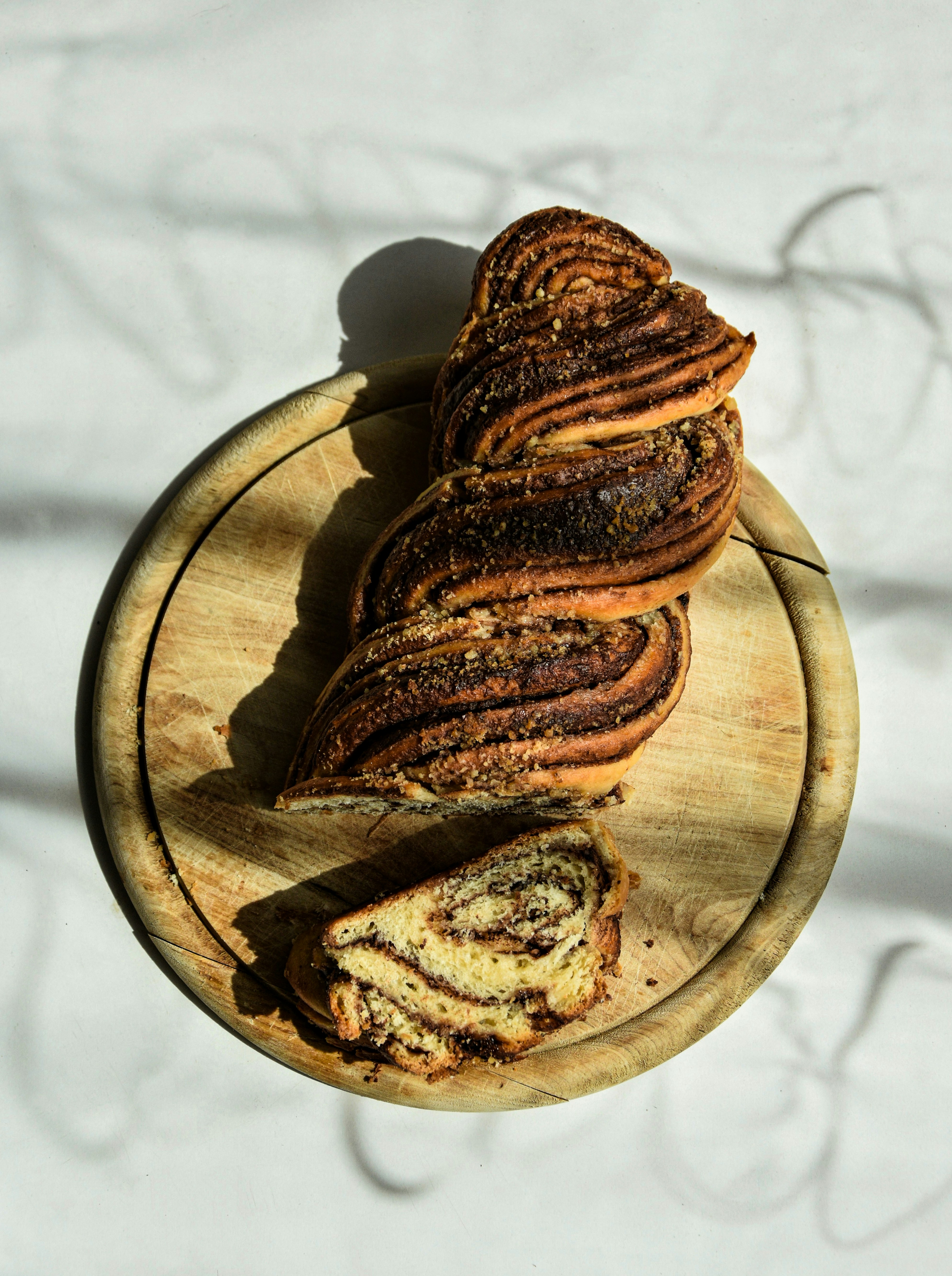 Twisted Golden Swirl: a loaf of babka on a wooden round