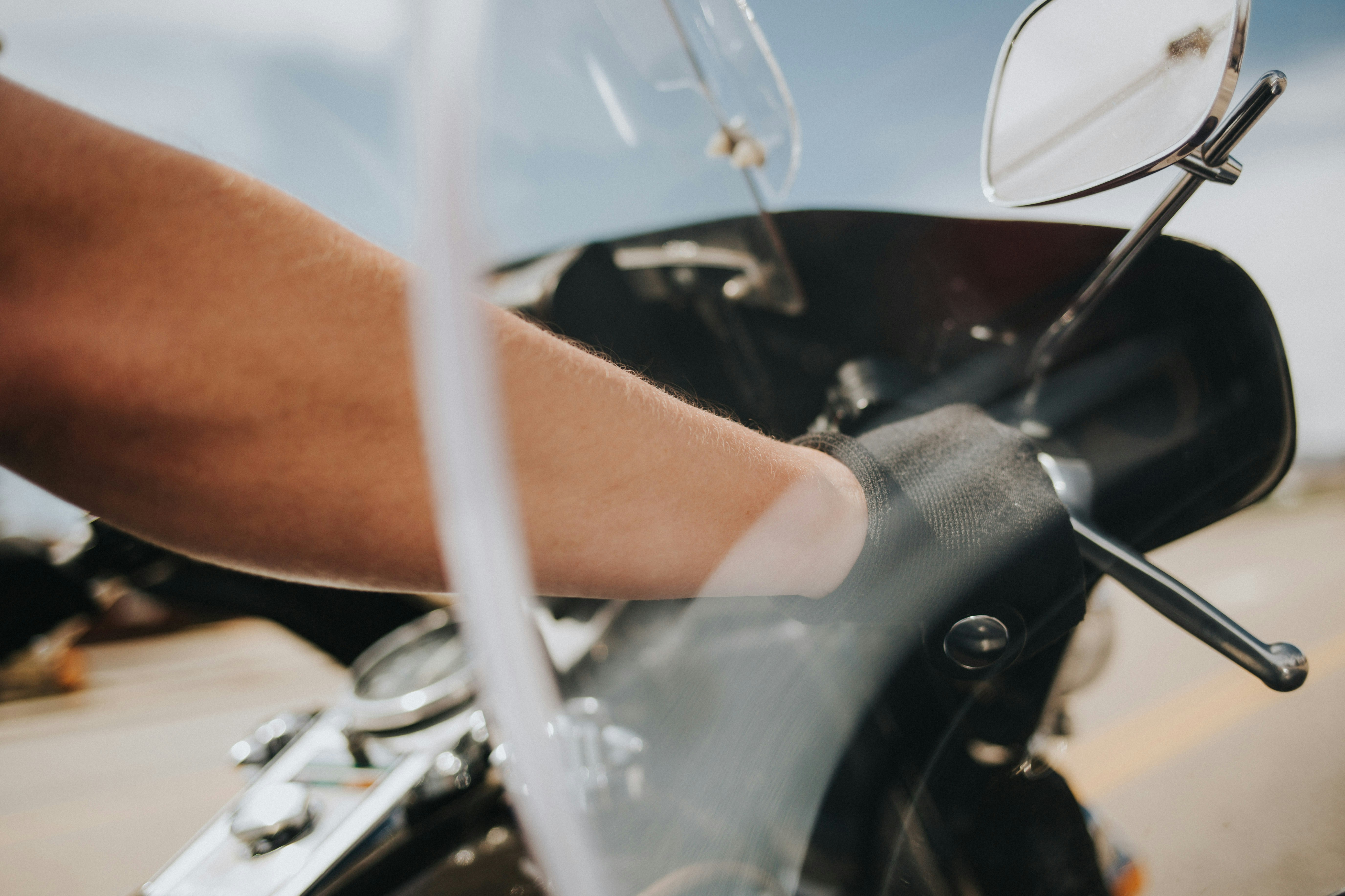 Gloved Hand on Chrome and Windshield: A Motorcycle Portrait in Motion