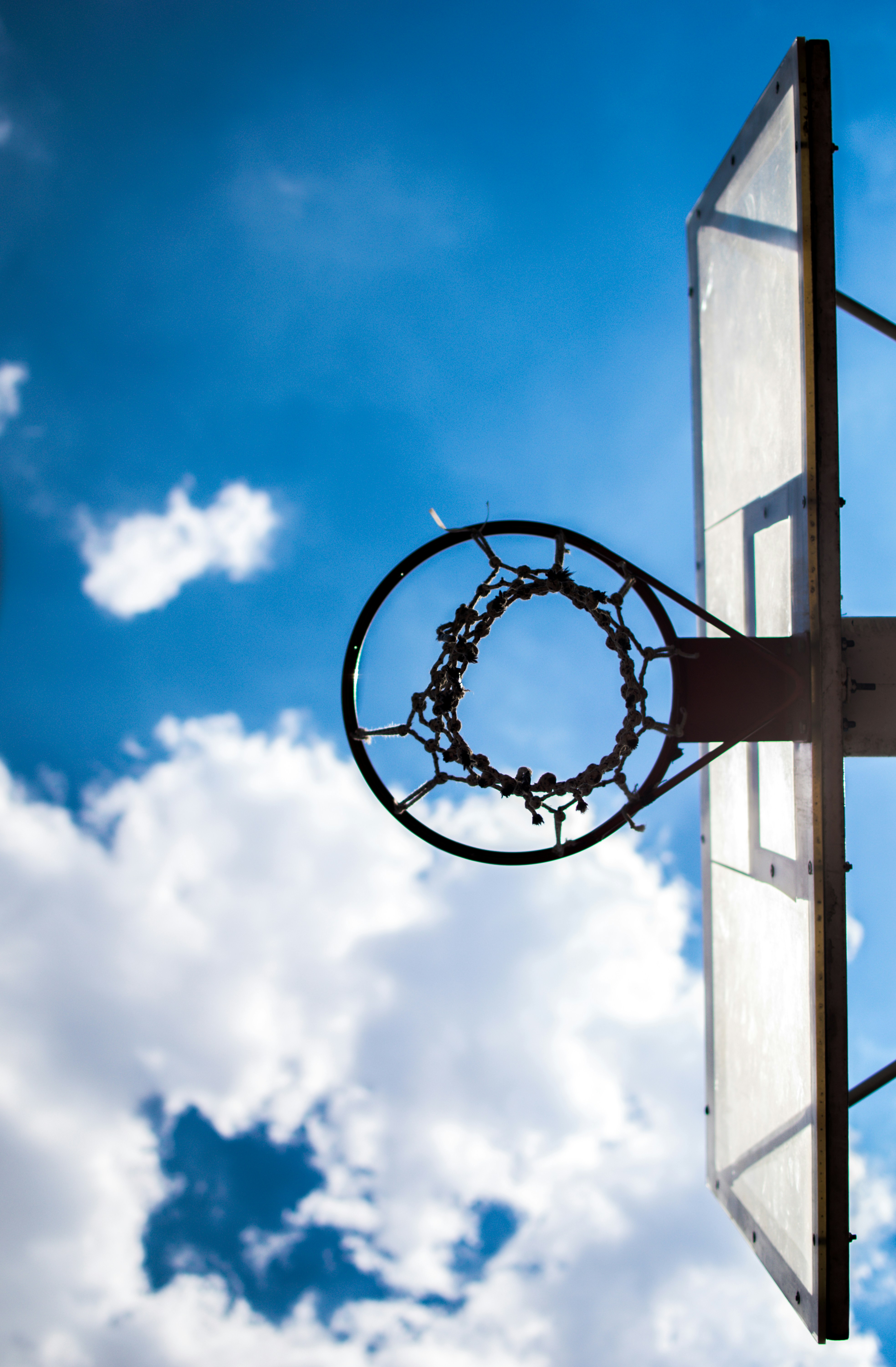 Rim Against the Sky: A Low-Angle Portrait of a Hoop