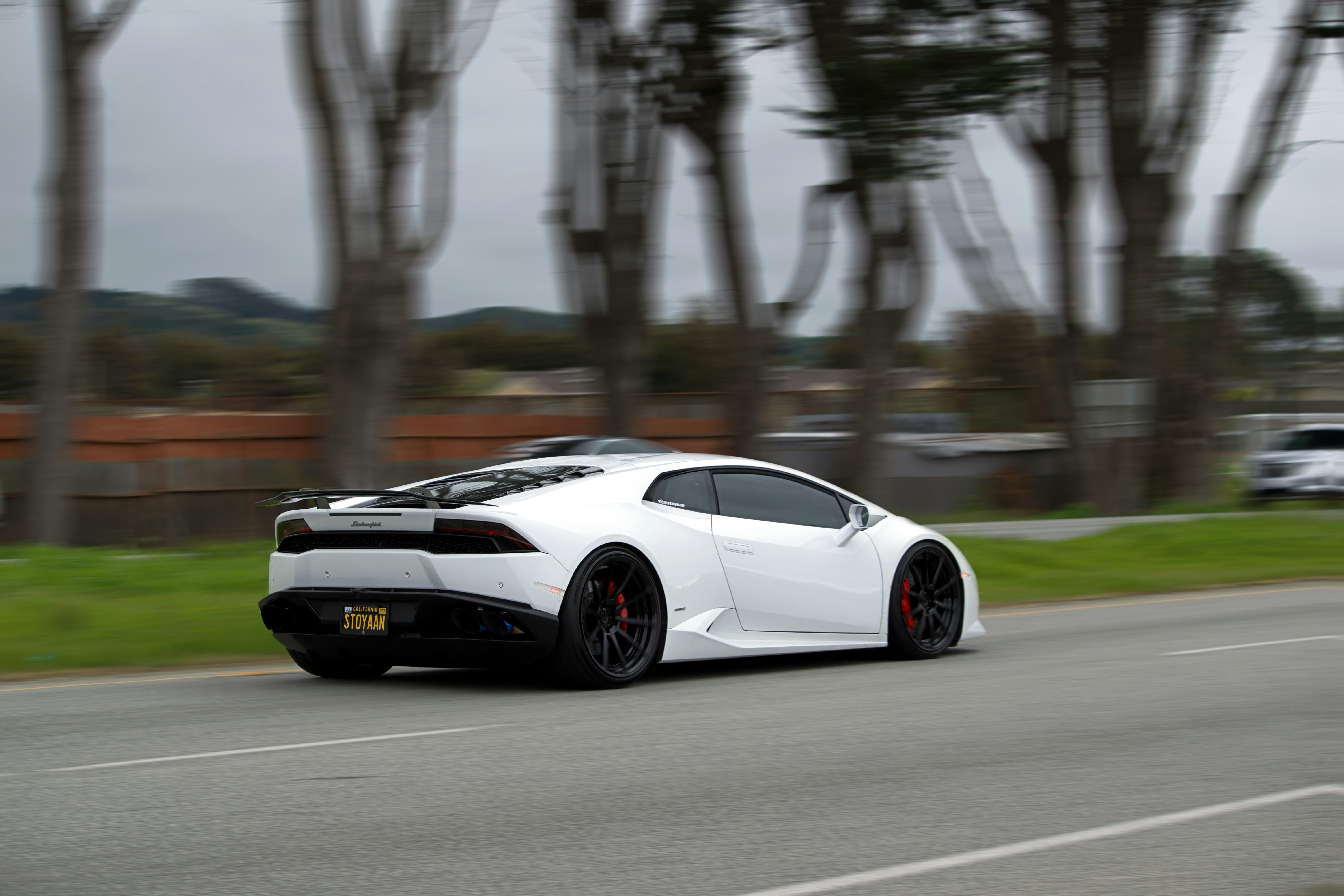 White supercar in motion on a suburban road