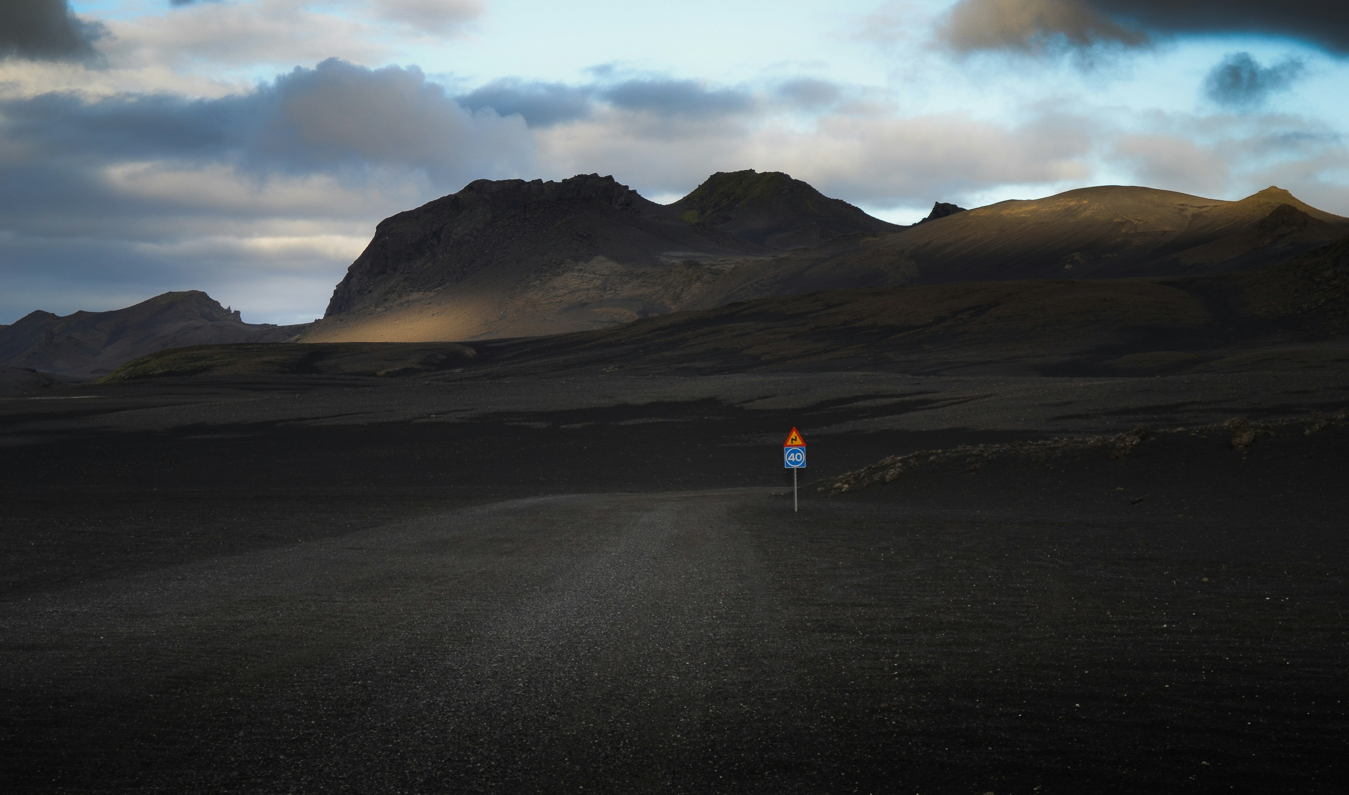 Person in white shirt walking on black asphalt road during daytime ...