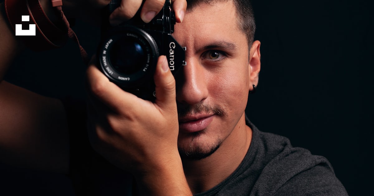 Hombre Con Camiseta Gris De Cuello Redondo Sosteniendo Una Cámara Dslr