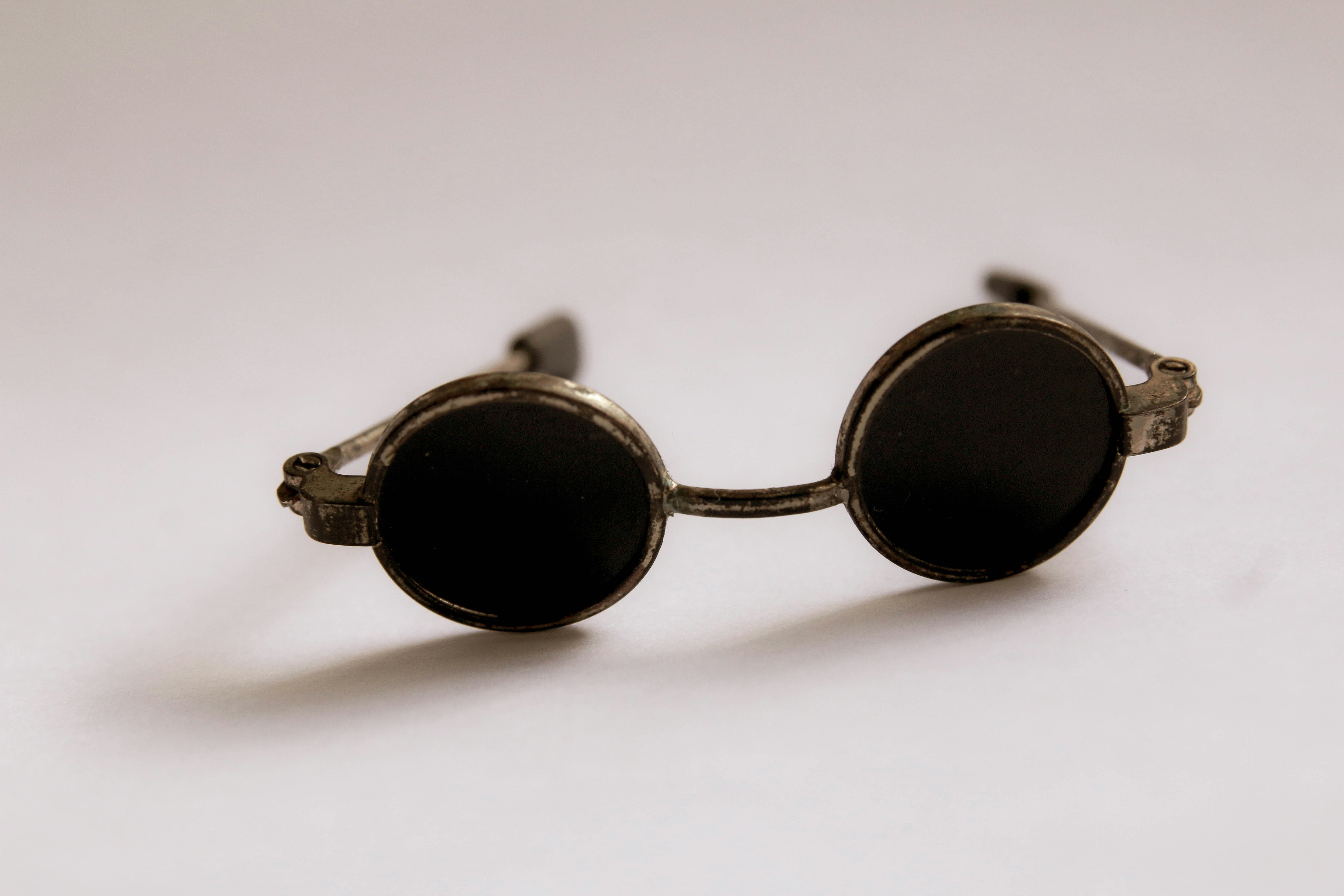 Vintage round sunglasses resting on a smooth surface, showcasing their unique design and craftsmanship.