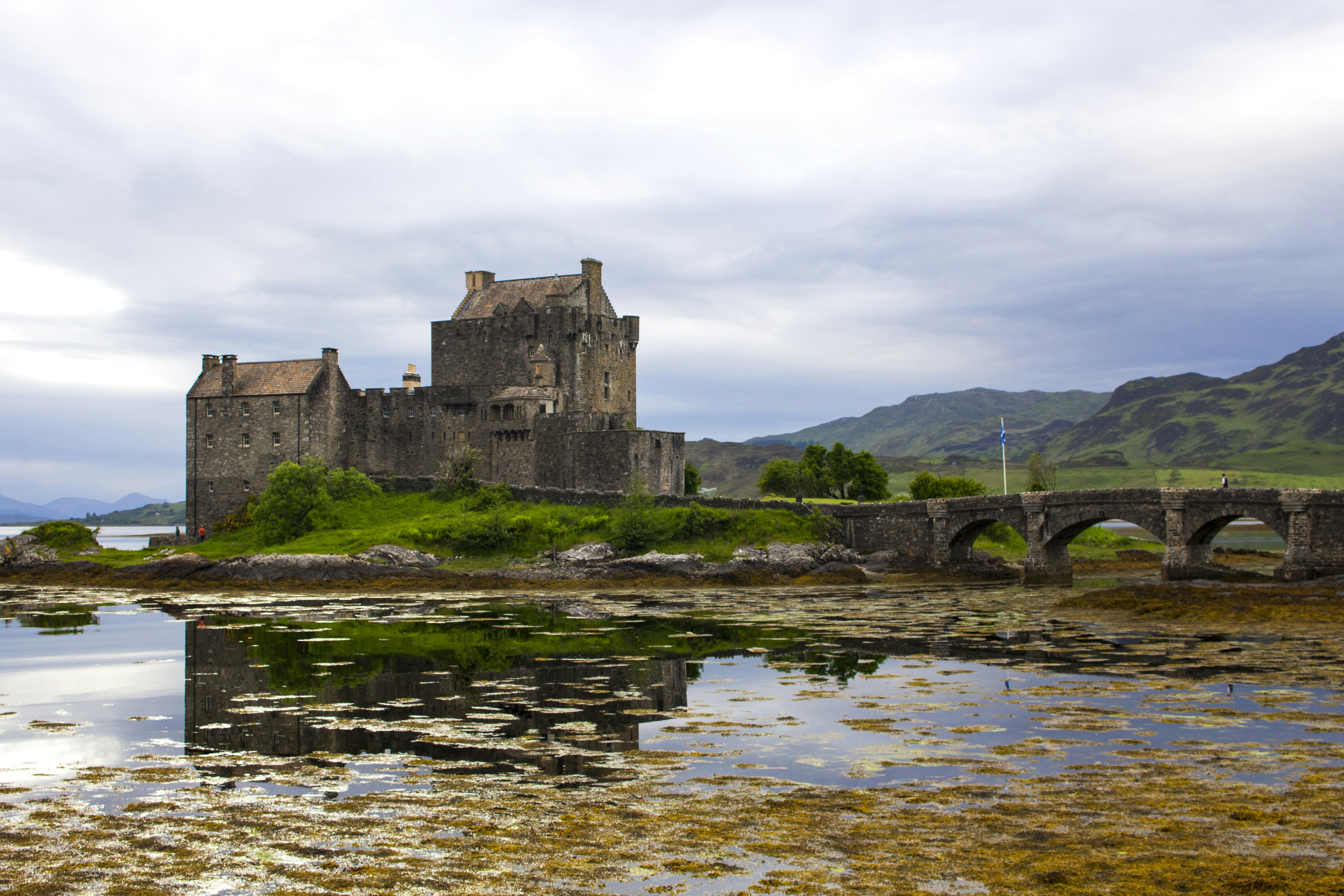 Brown concrete castle near body of water under cloudy sky during ...