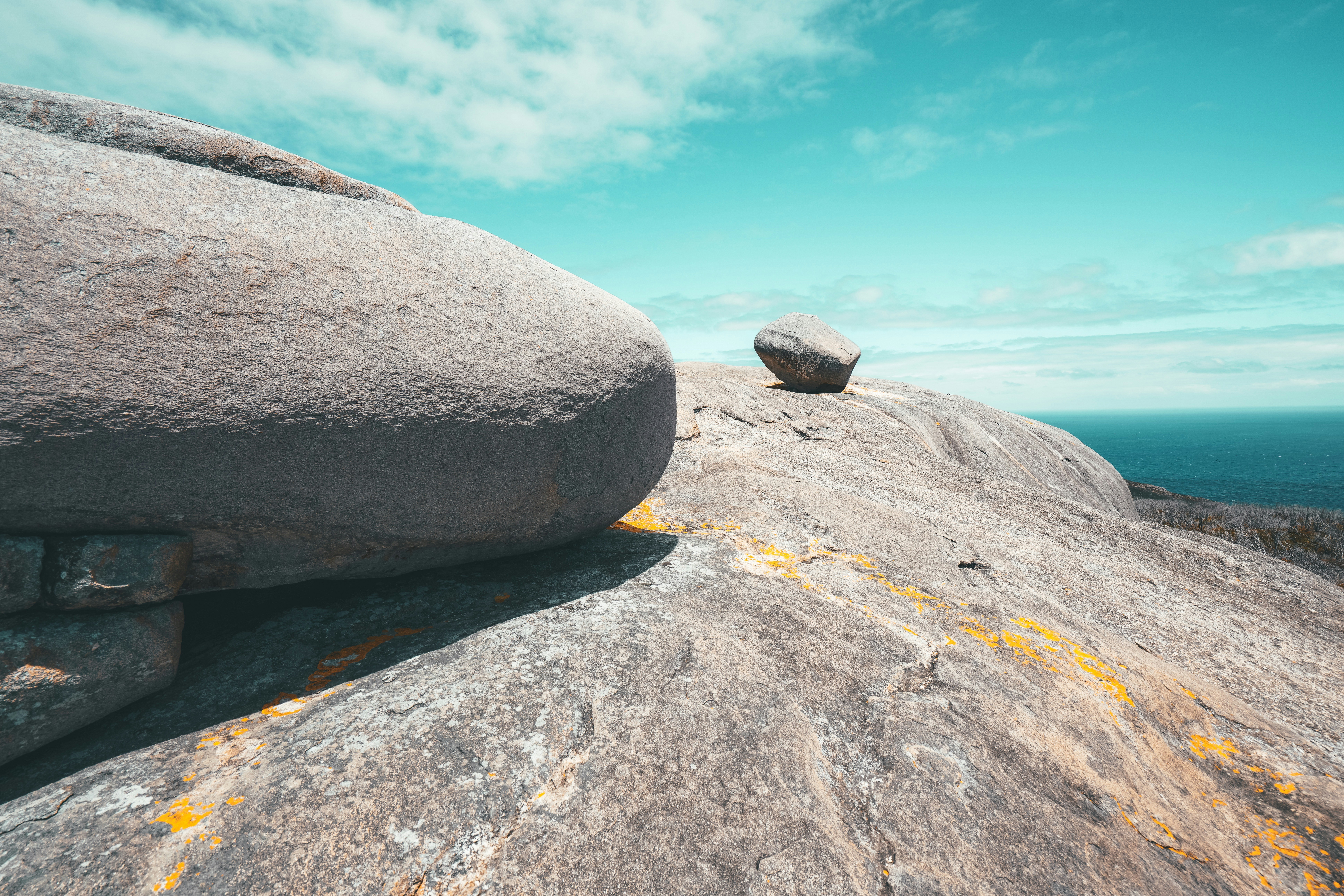 Lone Granite Outcrop Dwarfs the Sea under a Turquoise Sky