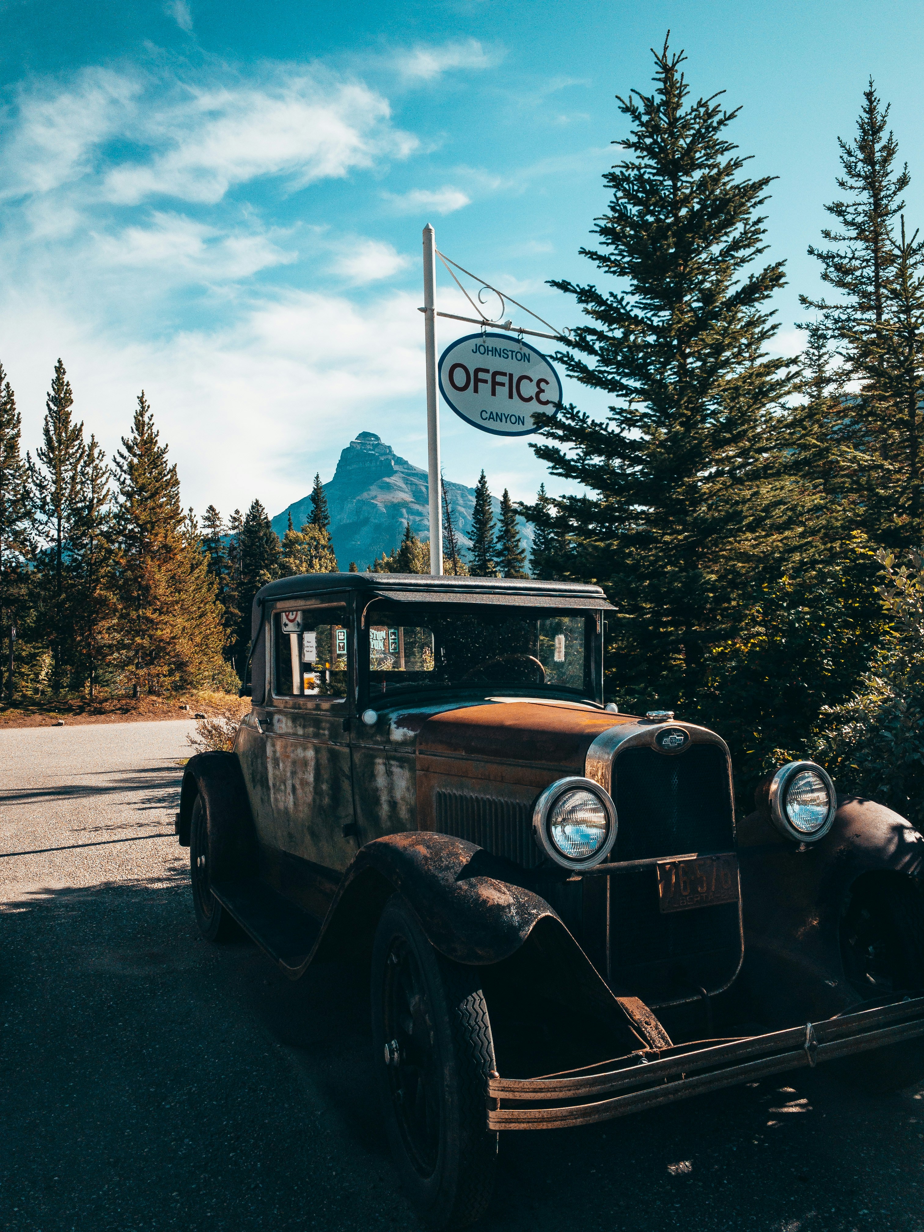 Rust and Road Sign: Vintage Truck Beneath Alpine Pines