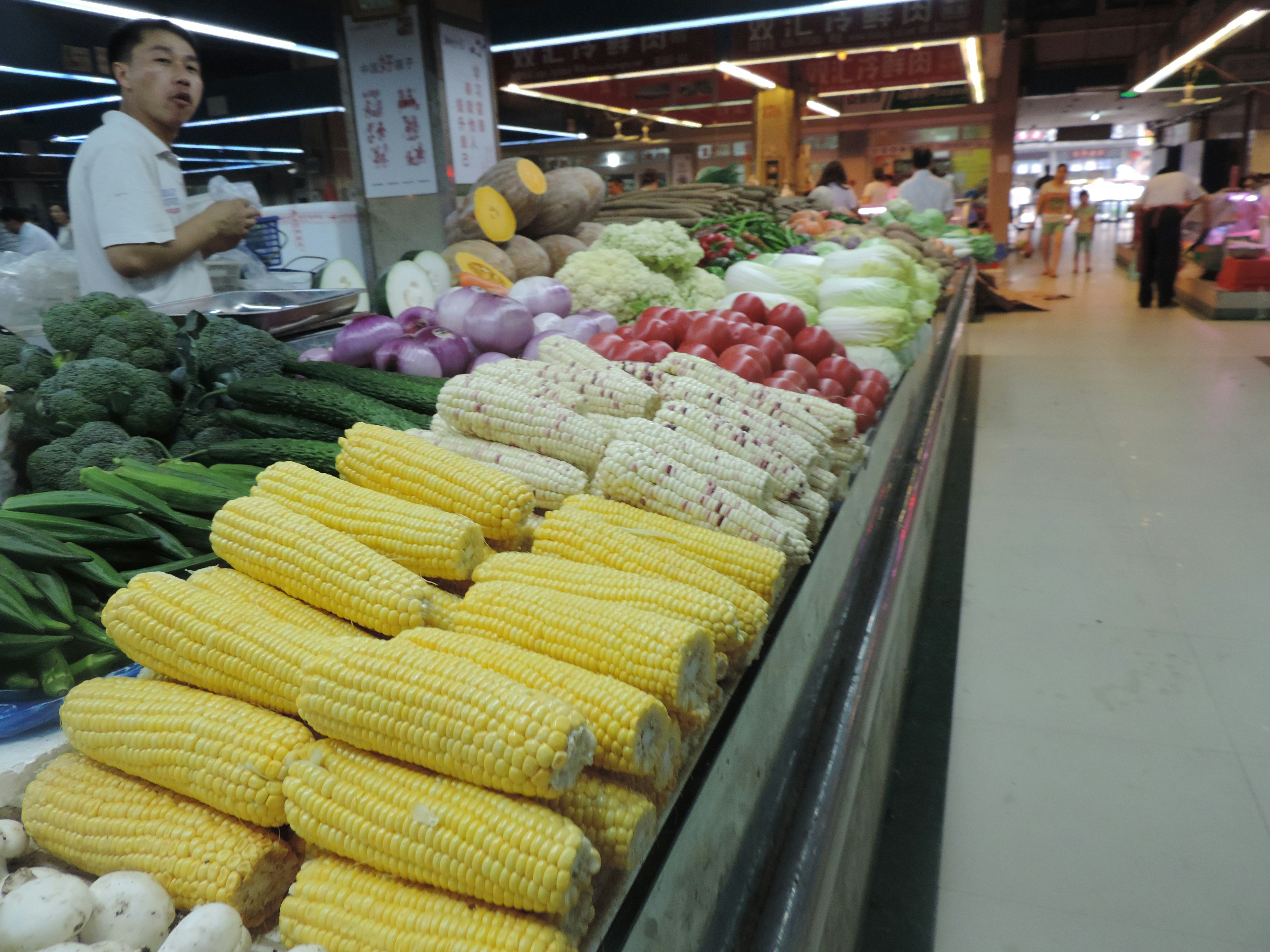 Vibrant display of fresh vegetables and corn at a bustling market, capturing the essence of local agriculture.