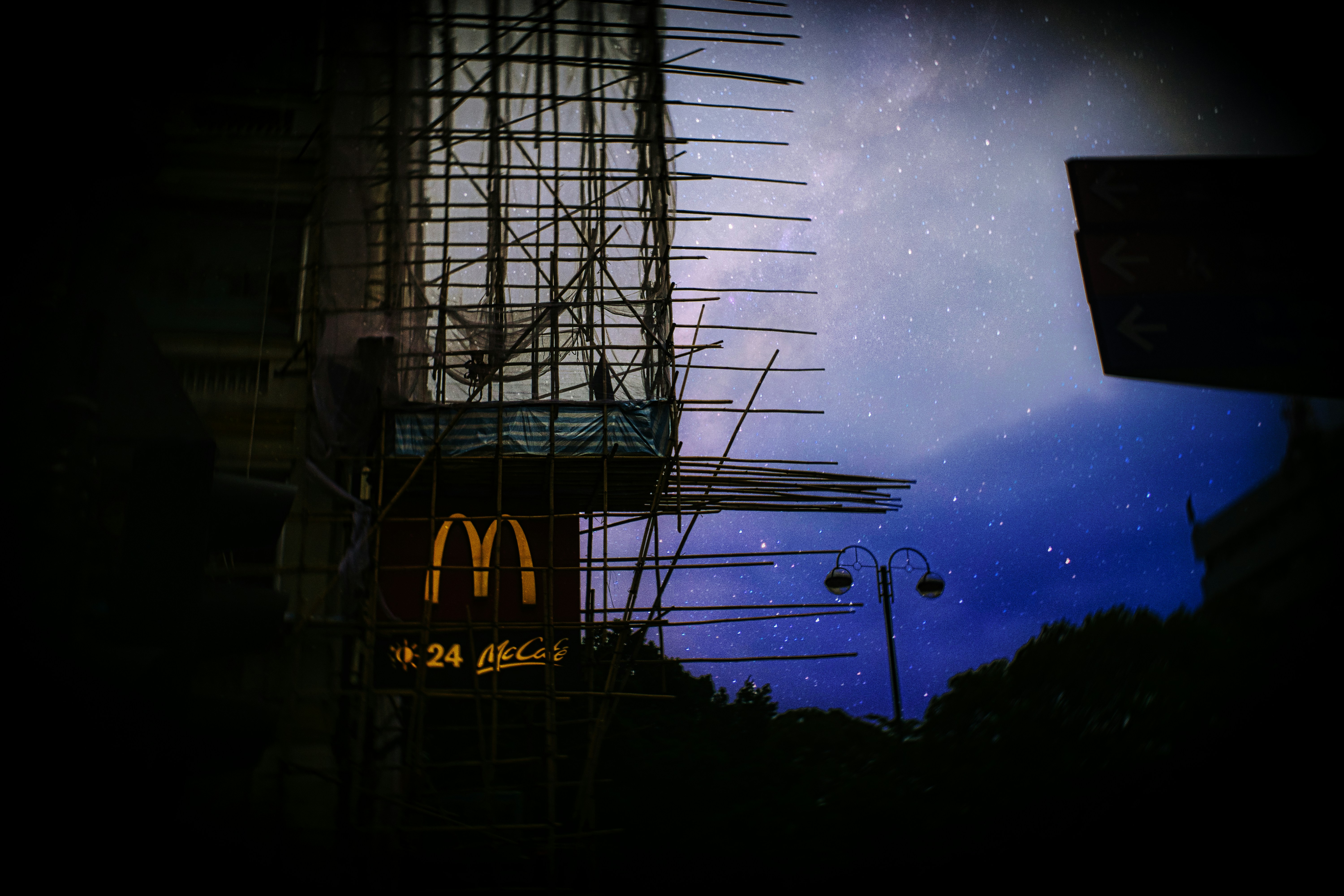 Moonlit Scaffold Framing the Golden Arches Under a Starry Night