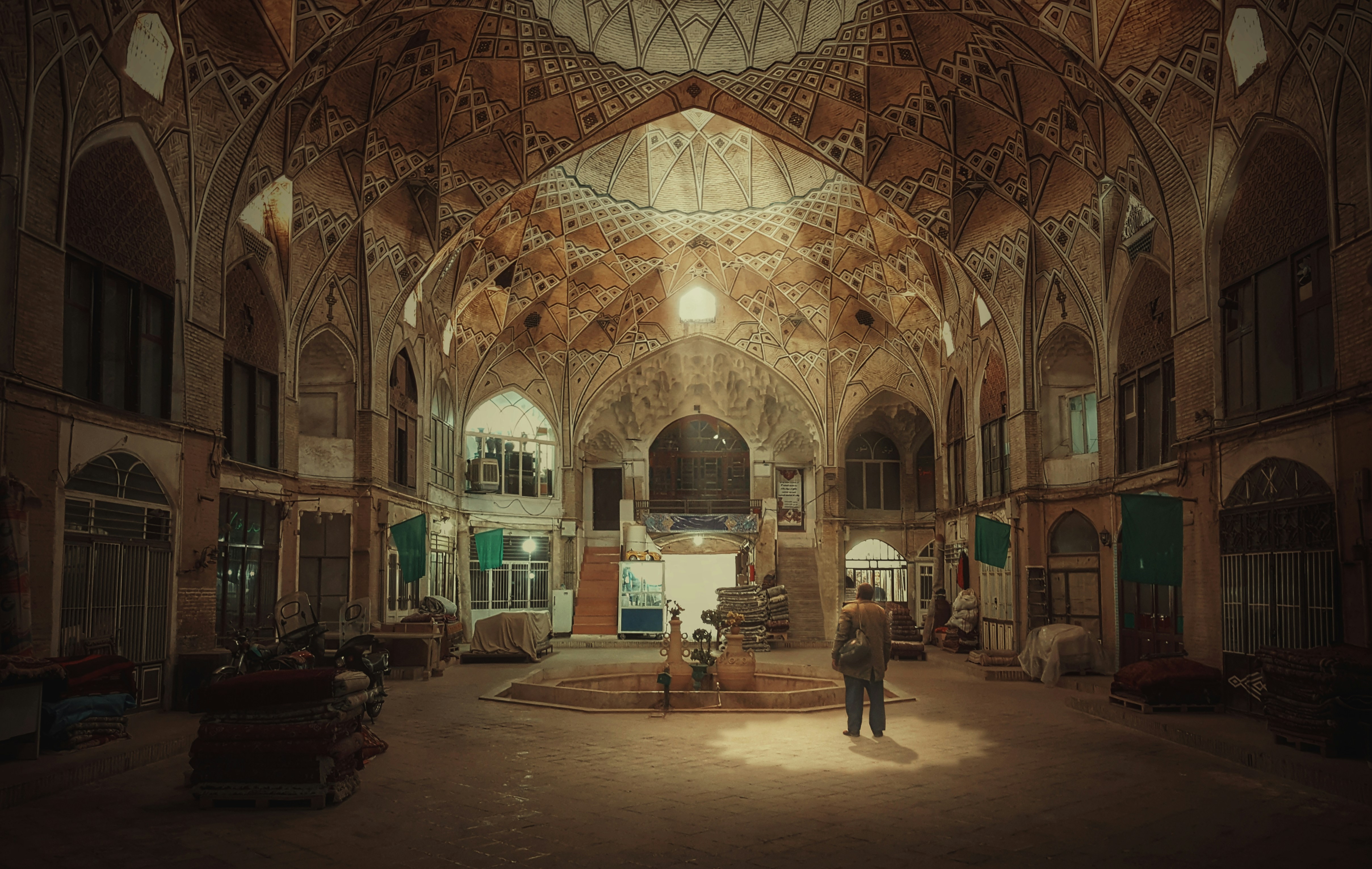 Sunbeams illuminate the ornate arches of an ancient bazaar, casting intricate shadows on the stone floor.