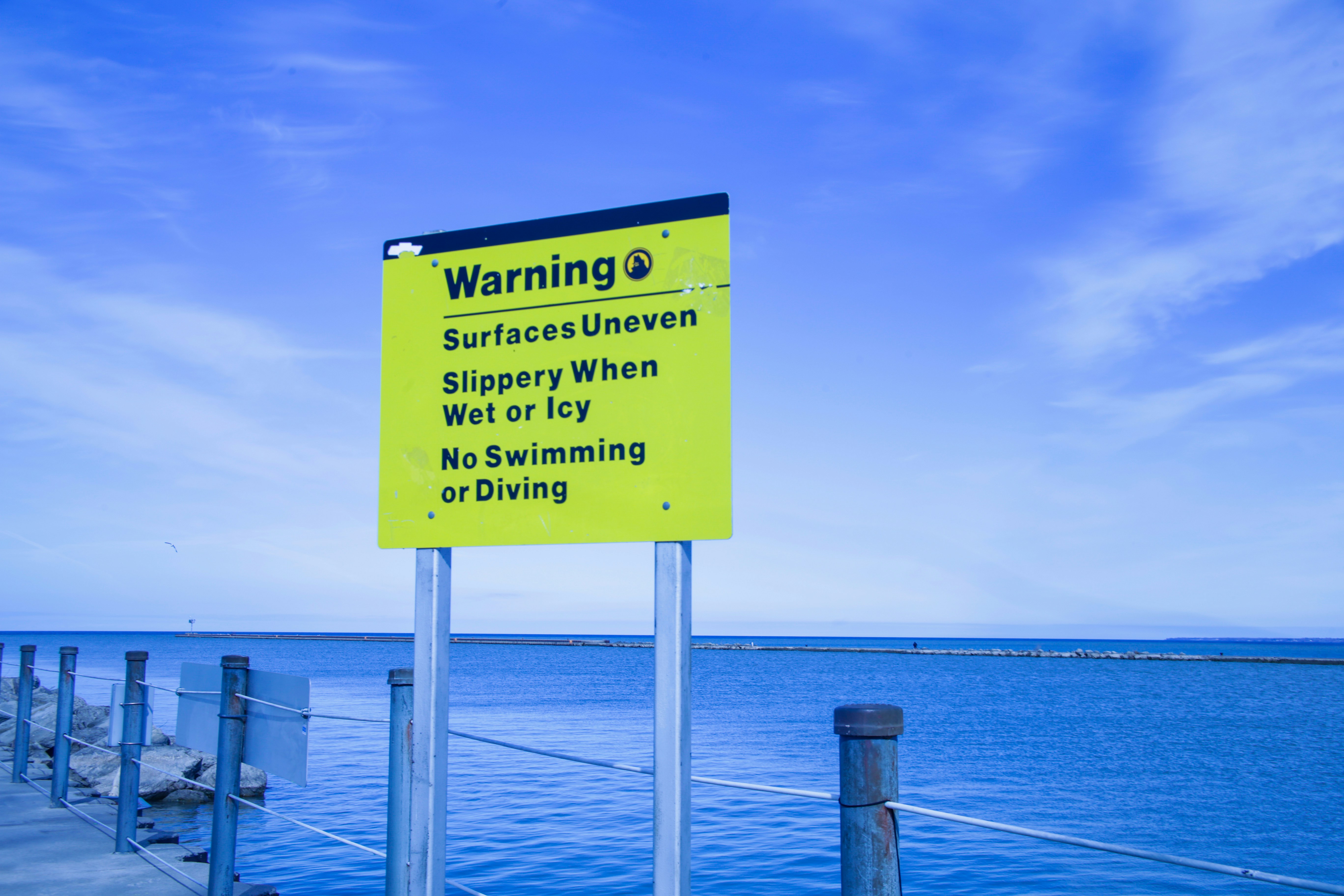Bright Warning: Slippery Sign by the Pier