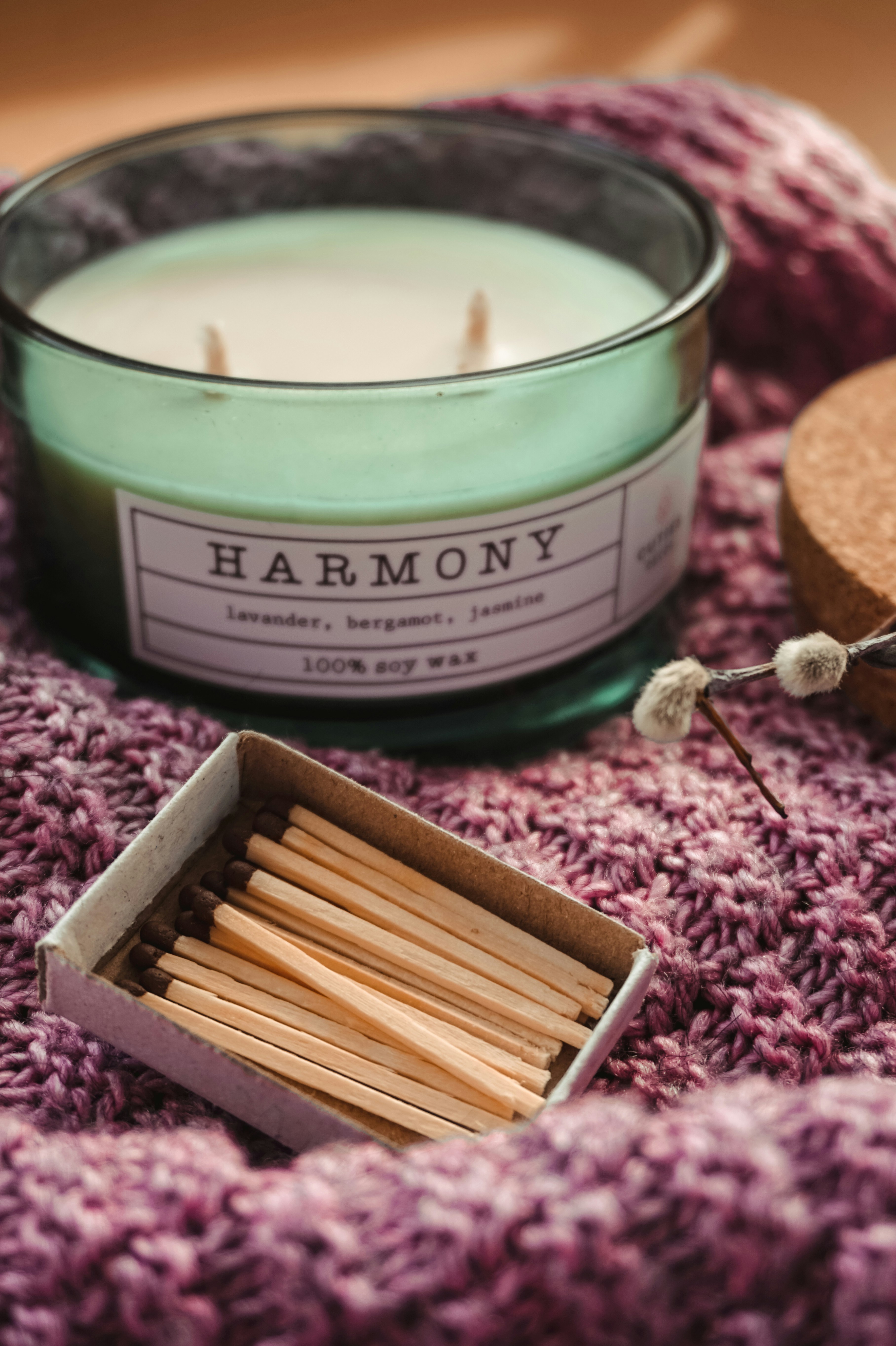 Harmony Candle in a Plush Purple Still-Life: Warm Glow on a Cozy Knit