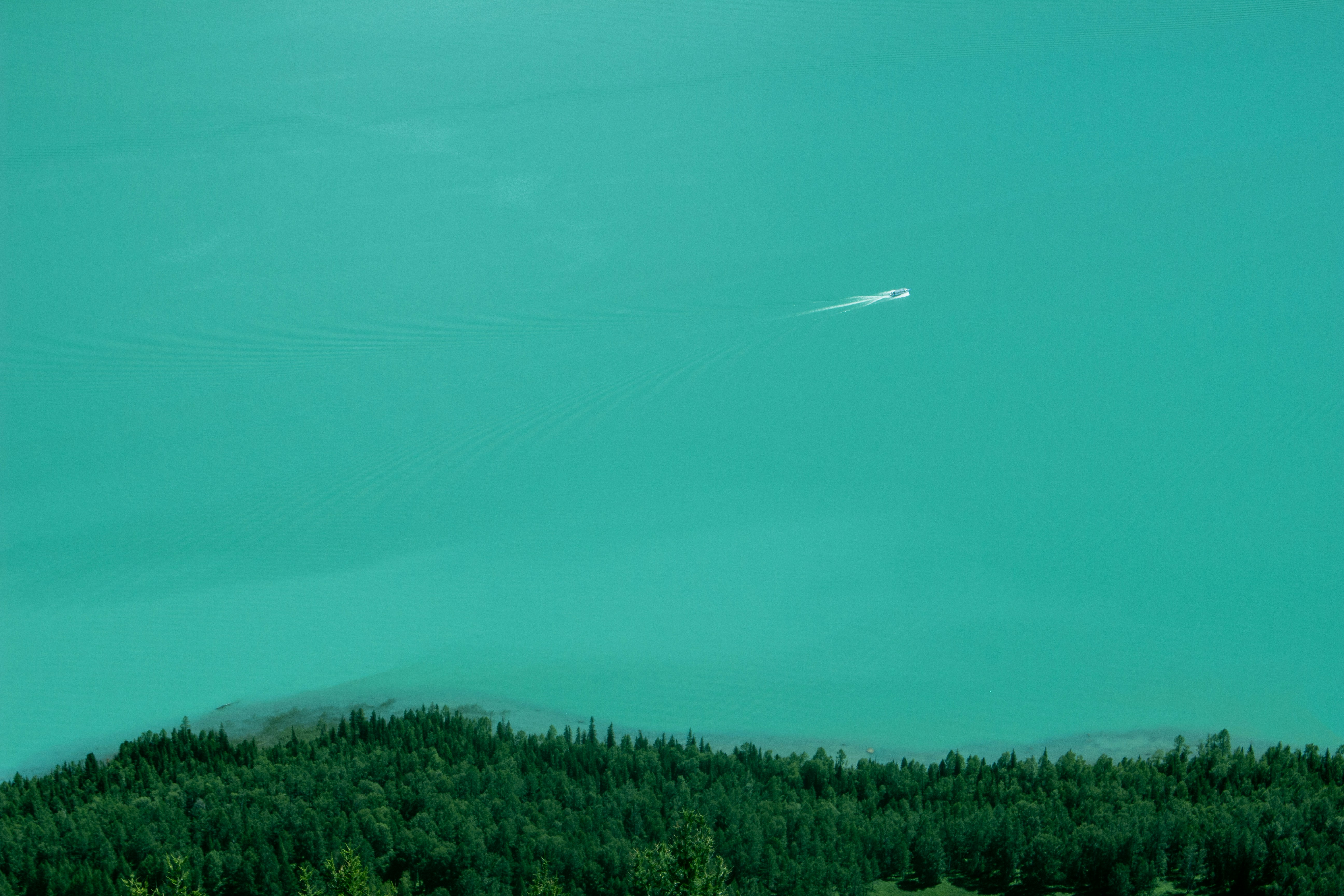 Jet over emerald sea: a lone wake across the turquoise horizon