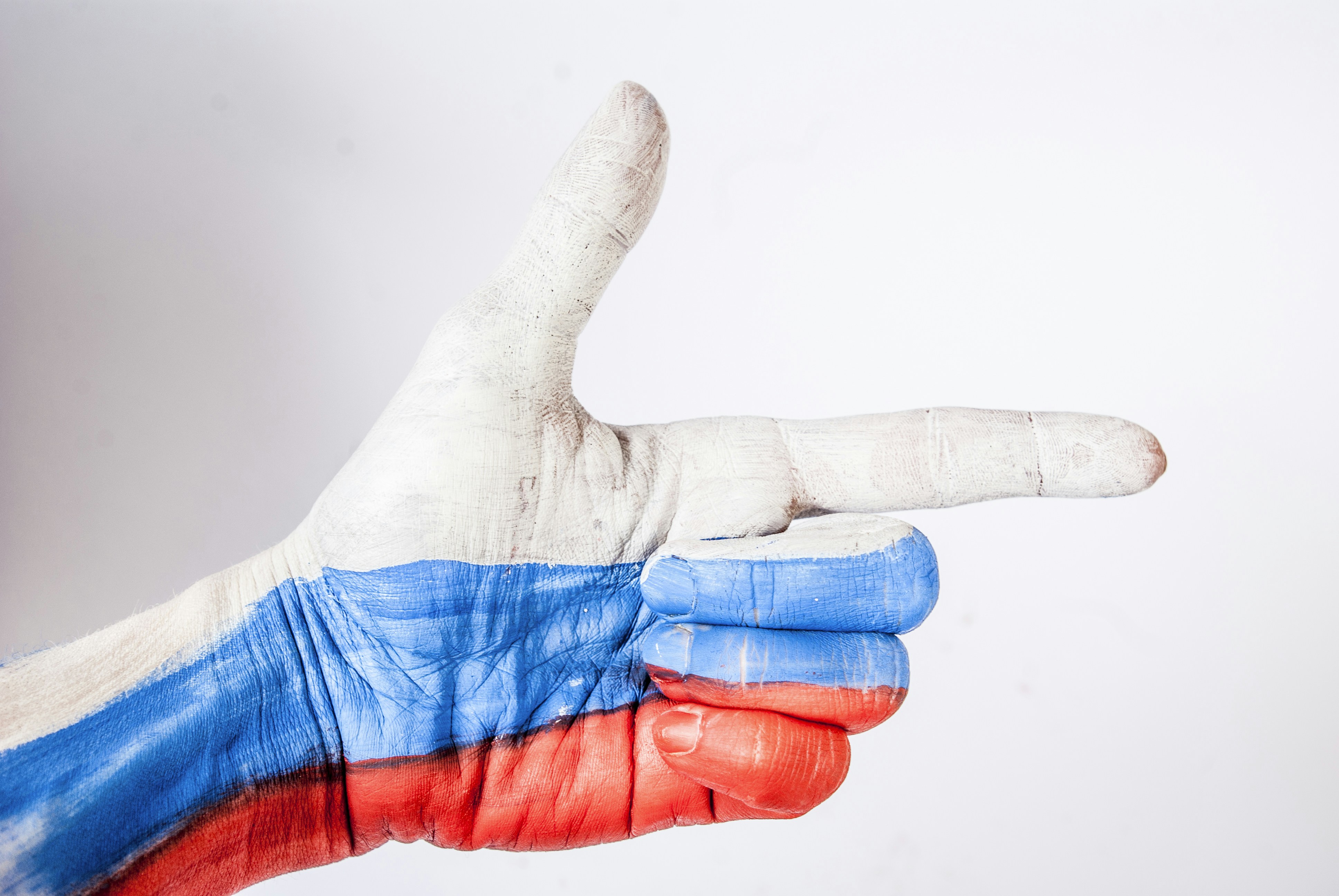 Hand painted in the colors of the Russian flag, forming a playful gesture against a neutral backdrop.