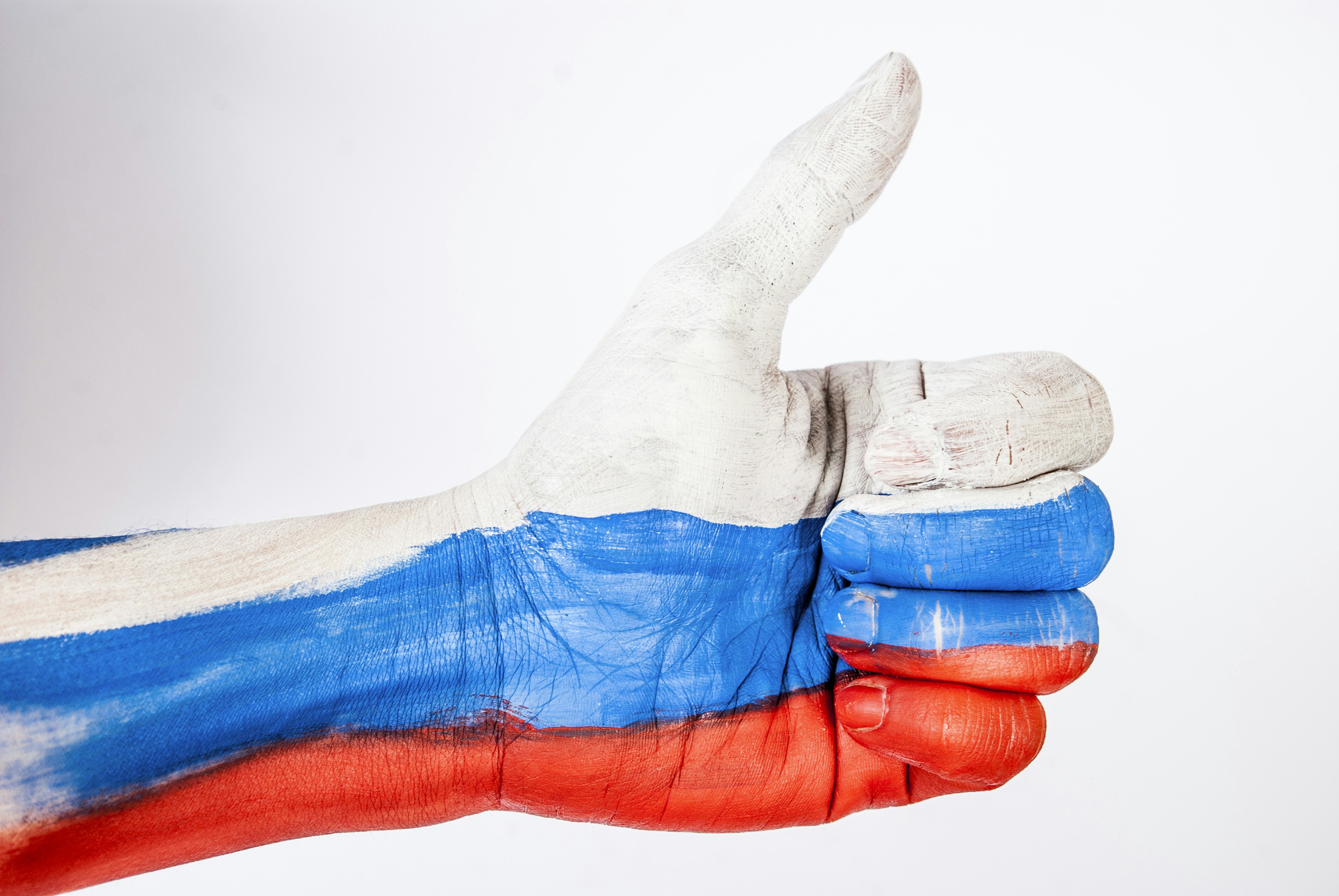Hand painted in the colors of the Russian flag forming a thumbs-up gesture against a white background.