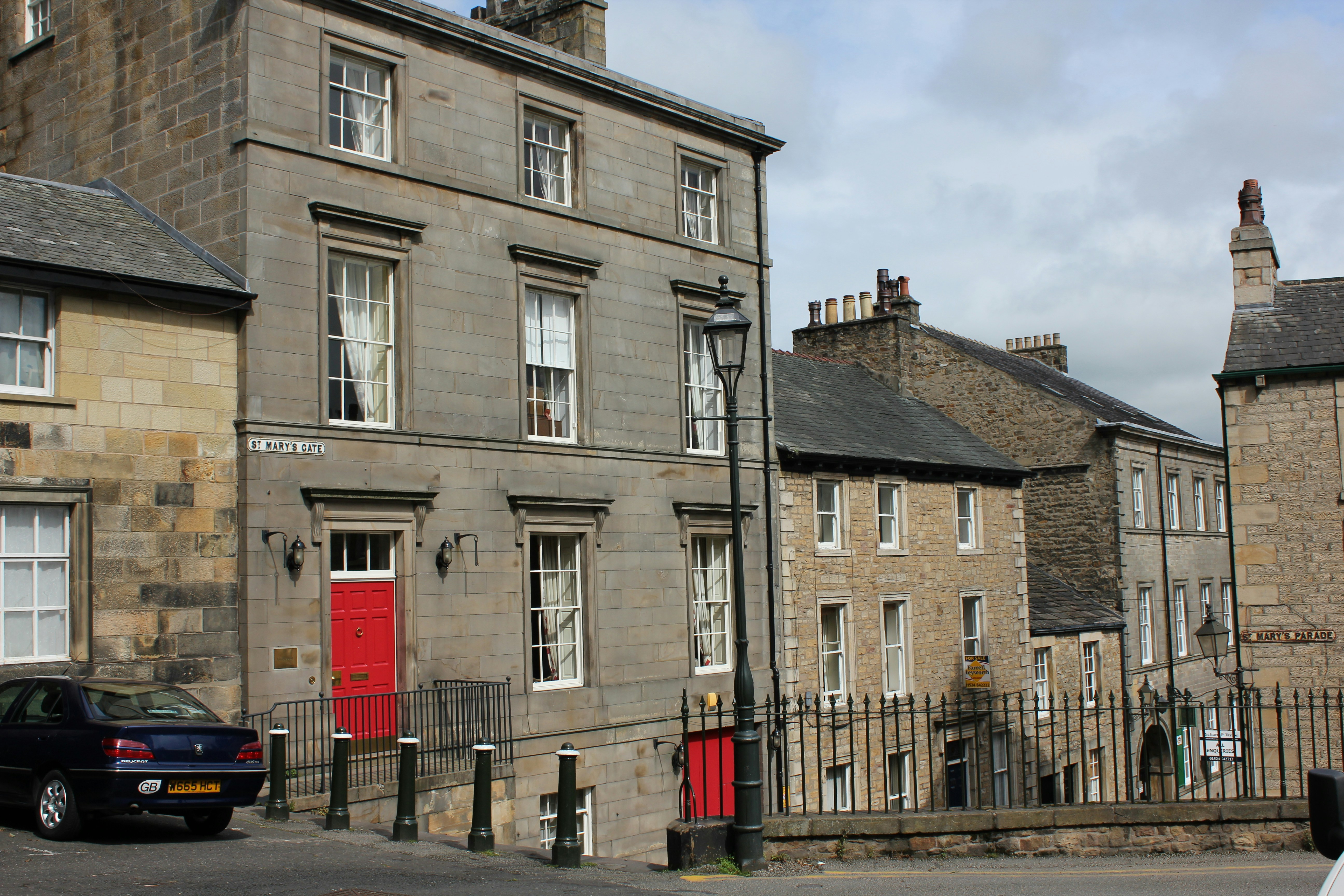 St Mary's Gate, just opposite Lancaster Castle. Red doors against old stone buildings.  | brown and white concrete building under white clouds during daytime