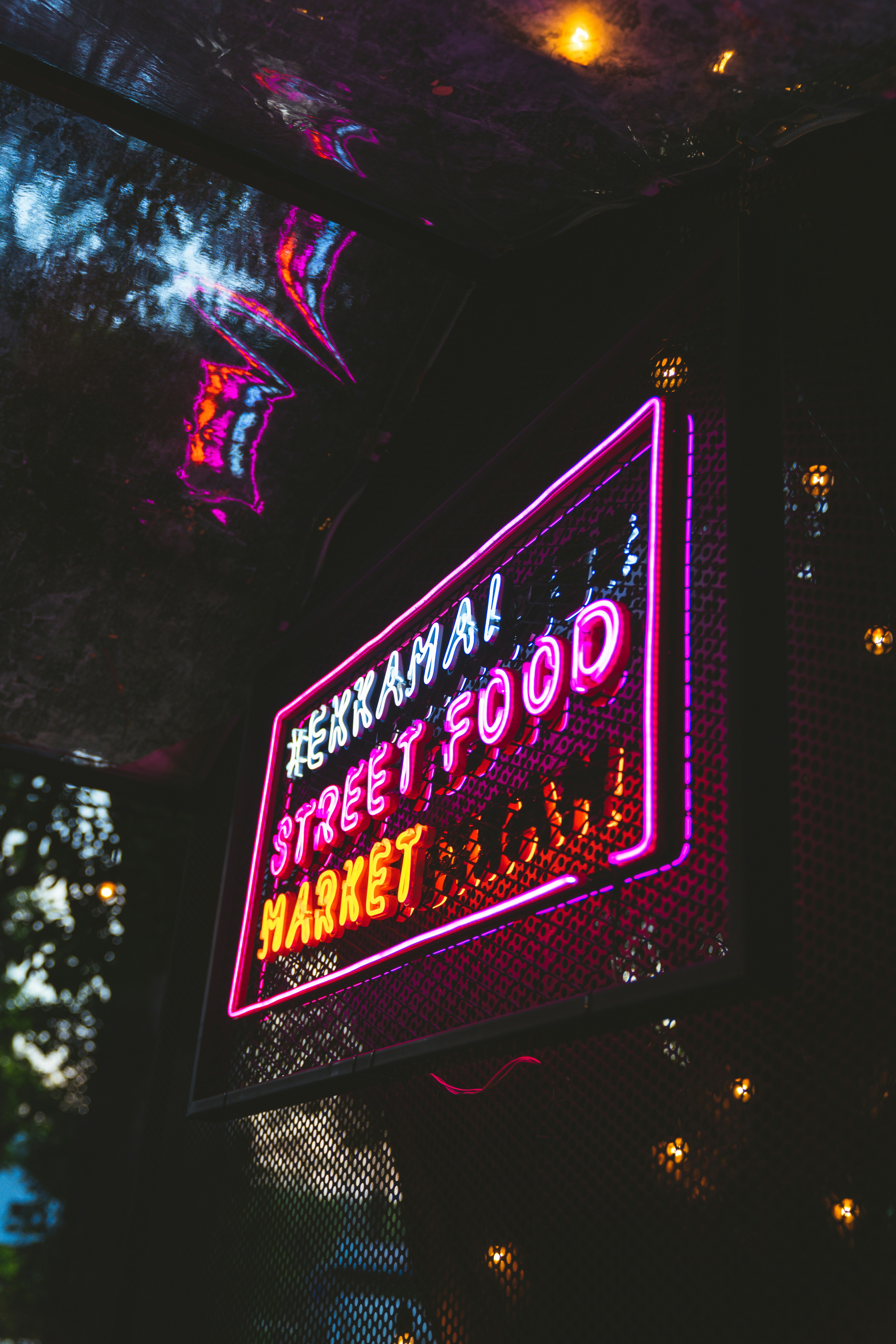 A neon sign hanging from the side of a building photo – Free Building ...