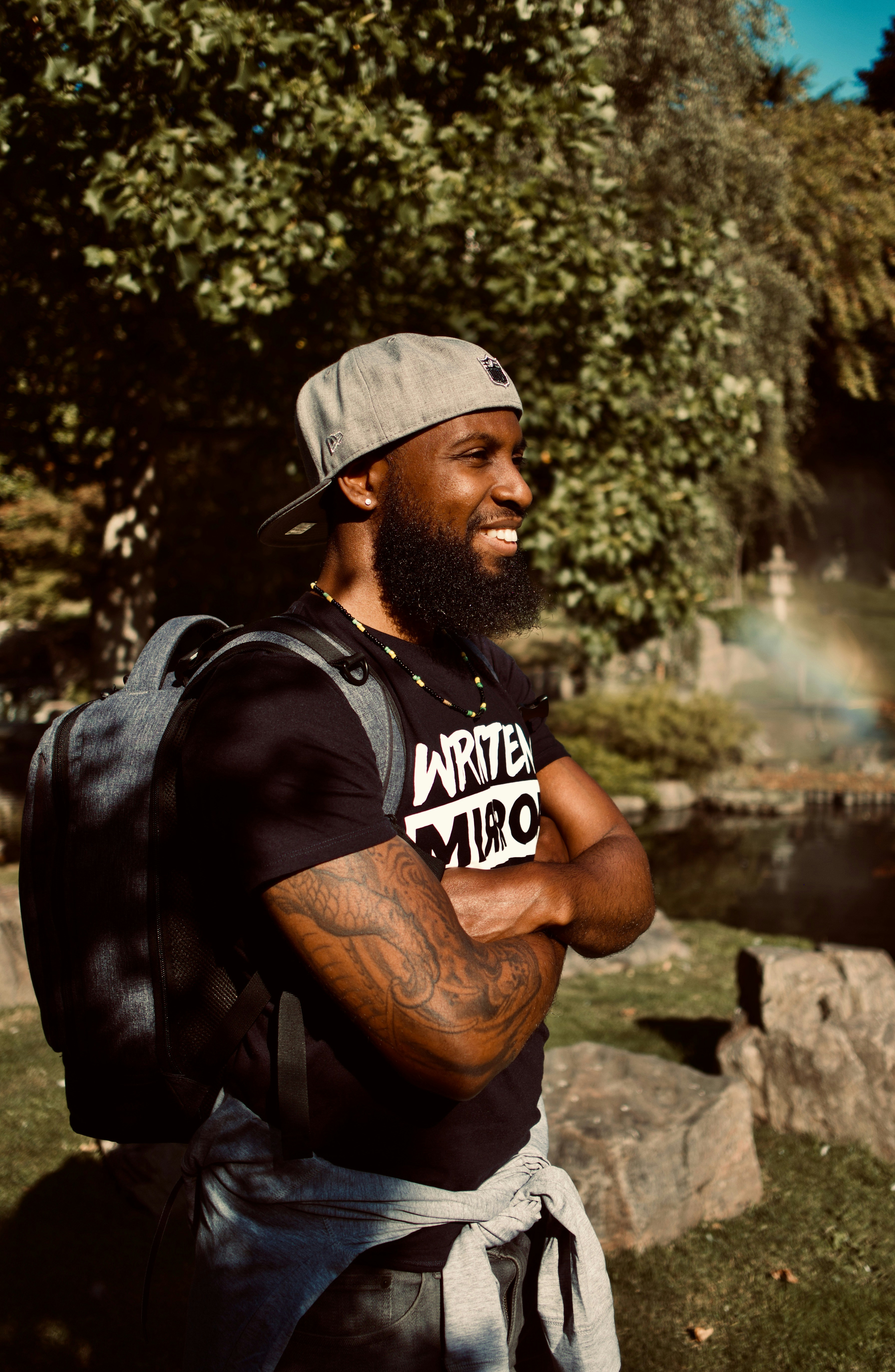 Backpack and Gaze: Bearded Portrait in Sunlit Park
