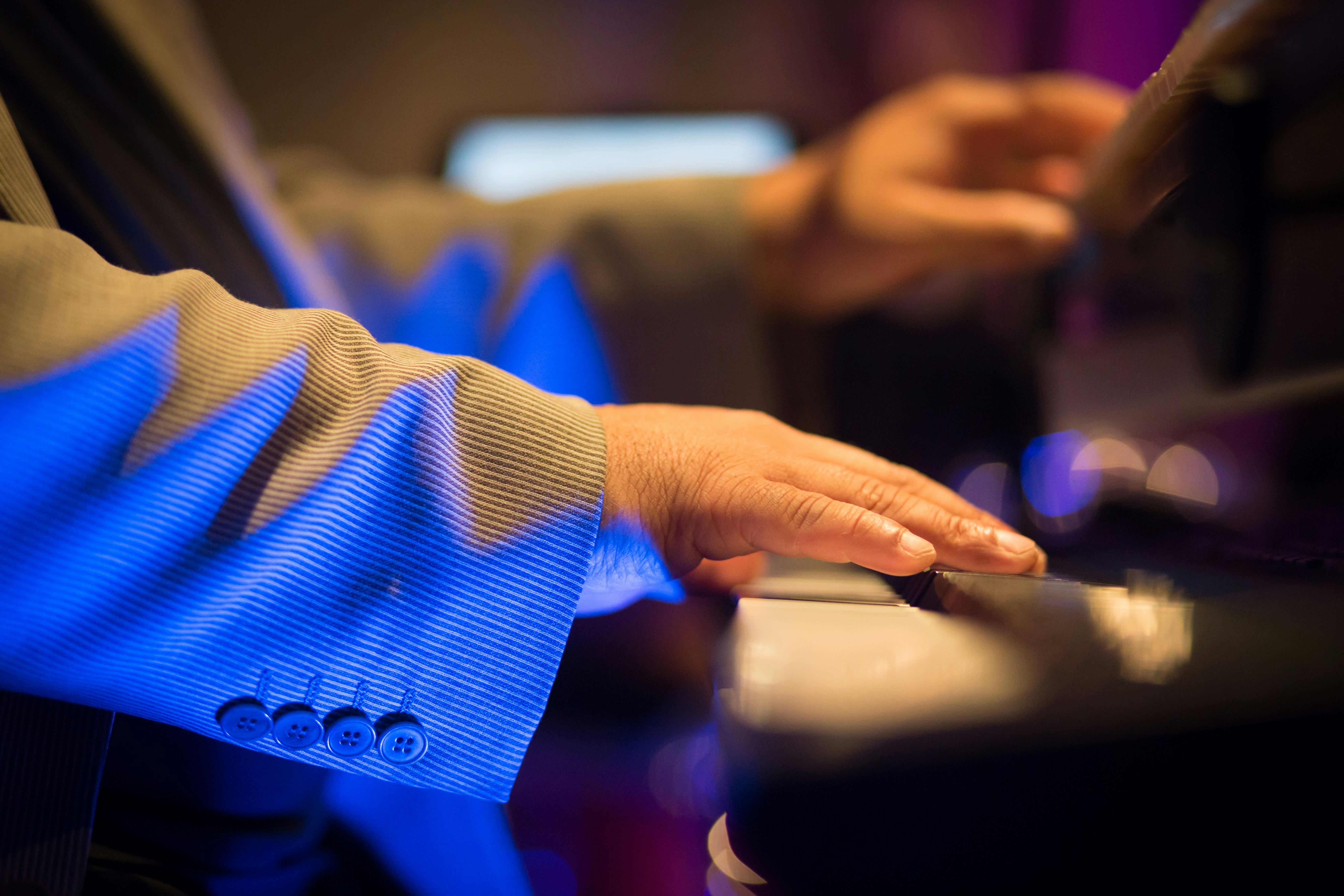 Blue Glow on the Keys: Close-Up of Hands at the Piano
