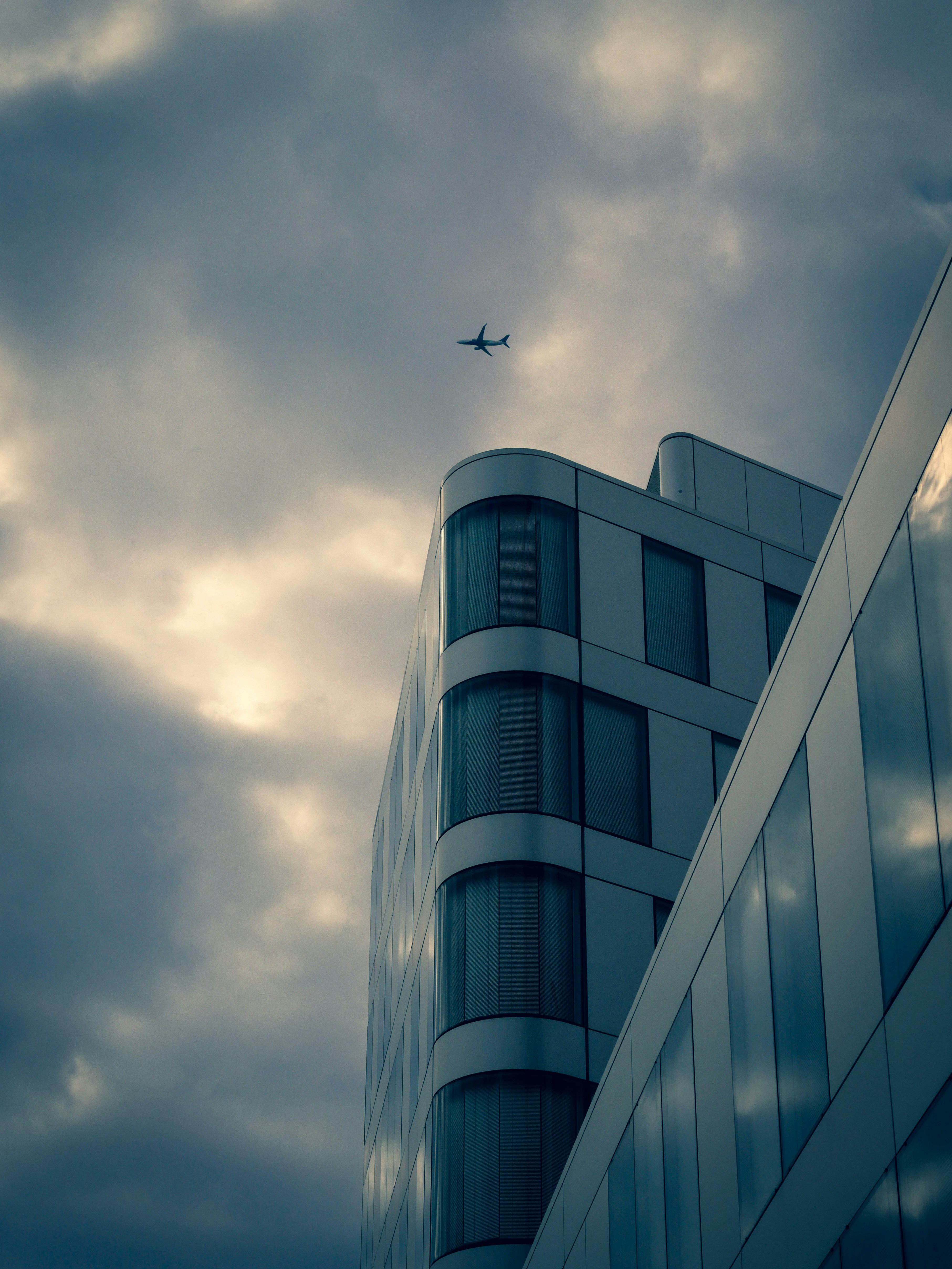 Airplane flying over gray building during daytime photo – Free ...