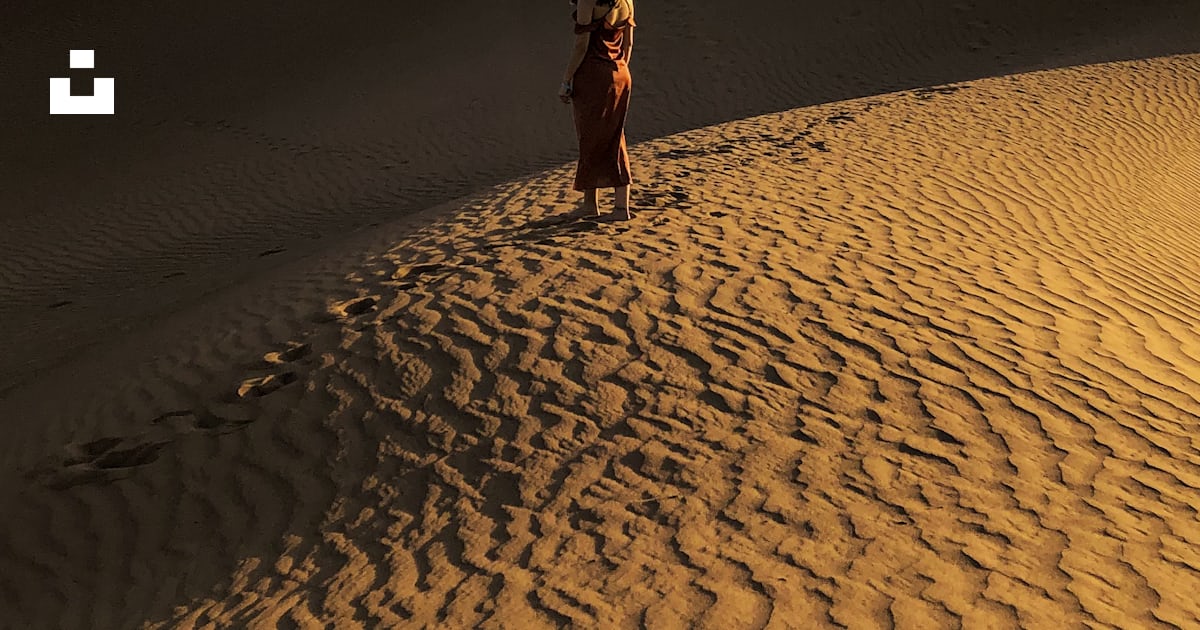 Foto Mujer En Vestido Negro Caminando En El Desierto Durante El Día