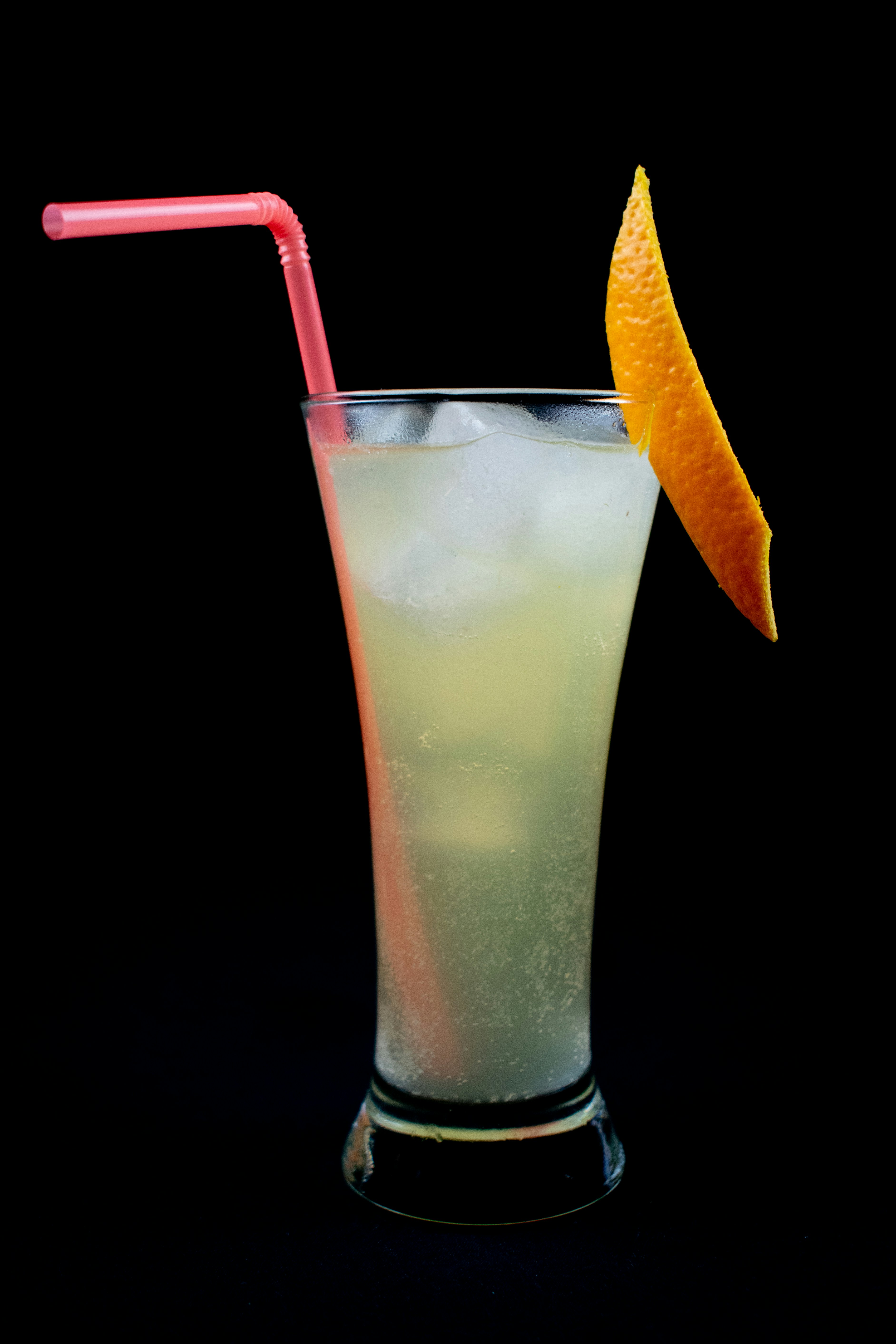 Citrus Gleam in a Tall Glass Against Velvet Black