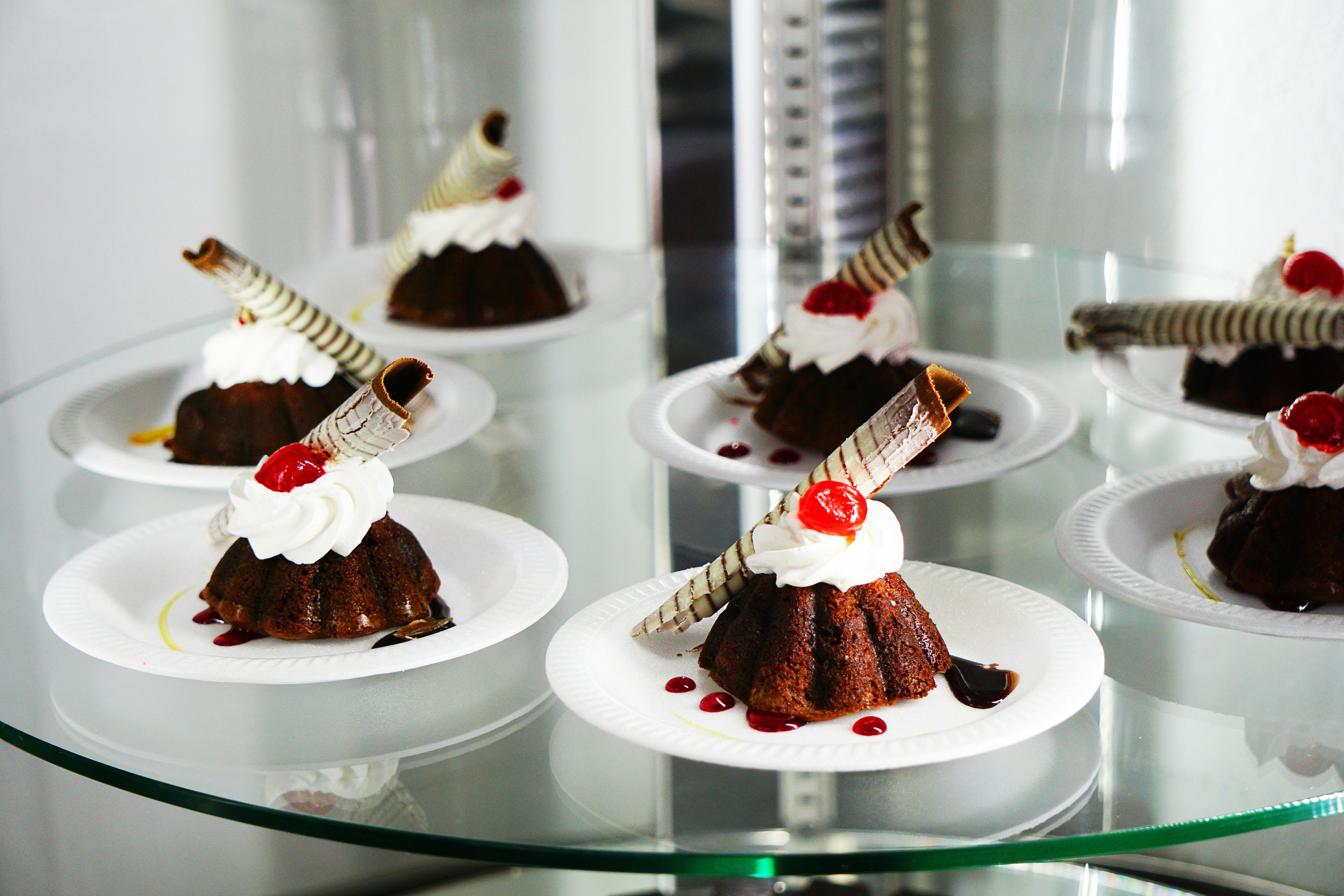 Assorted Chocolate Mousse Tarts with Whipped Cream and Strawberry Garnish