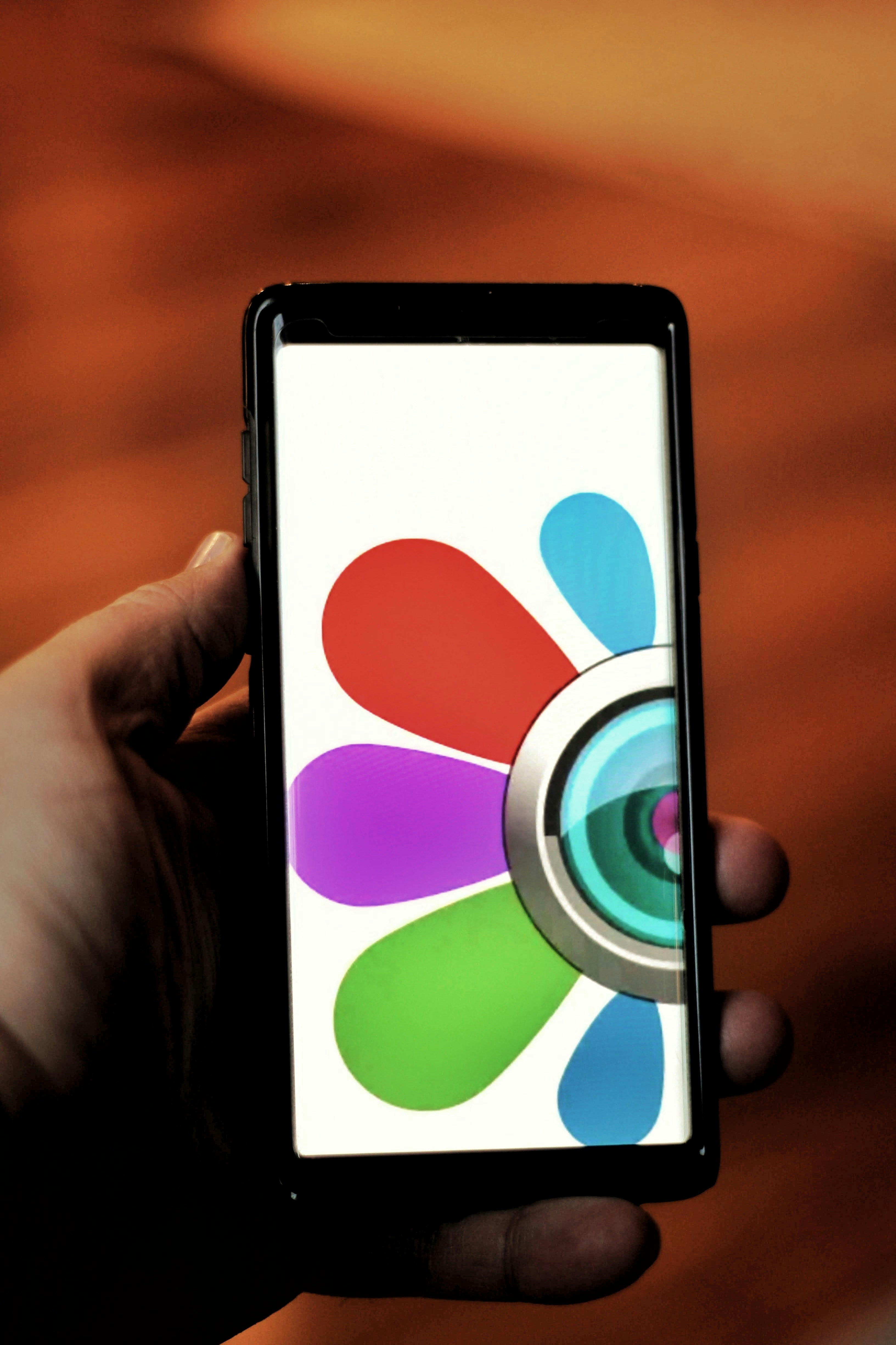 Midnight Portrait: Handheld Phone Framing the Colorful Lens