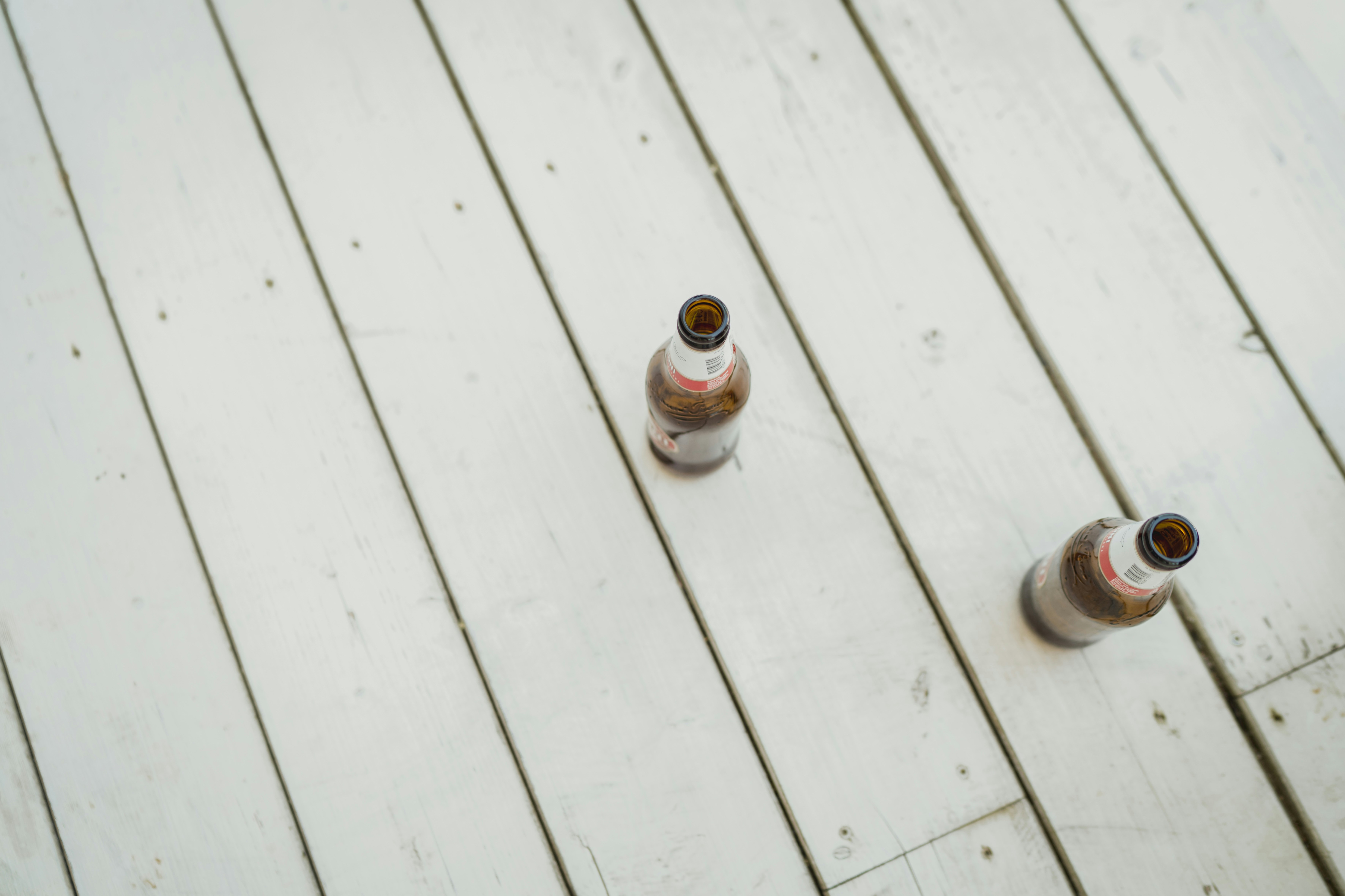 three brown and silver cans on white wooden floor