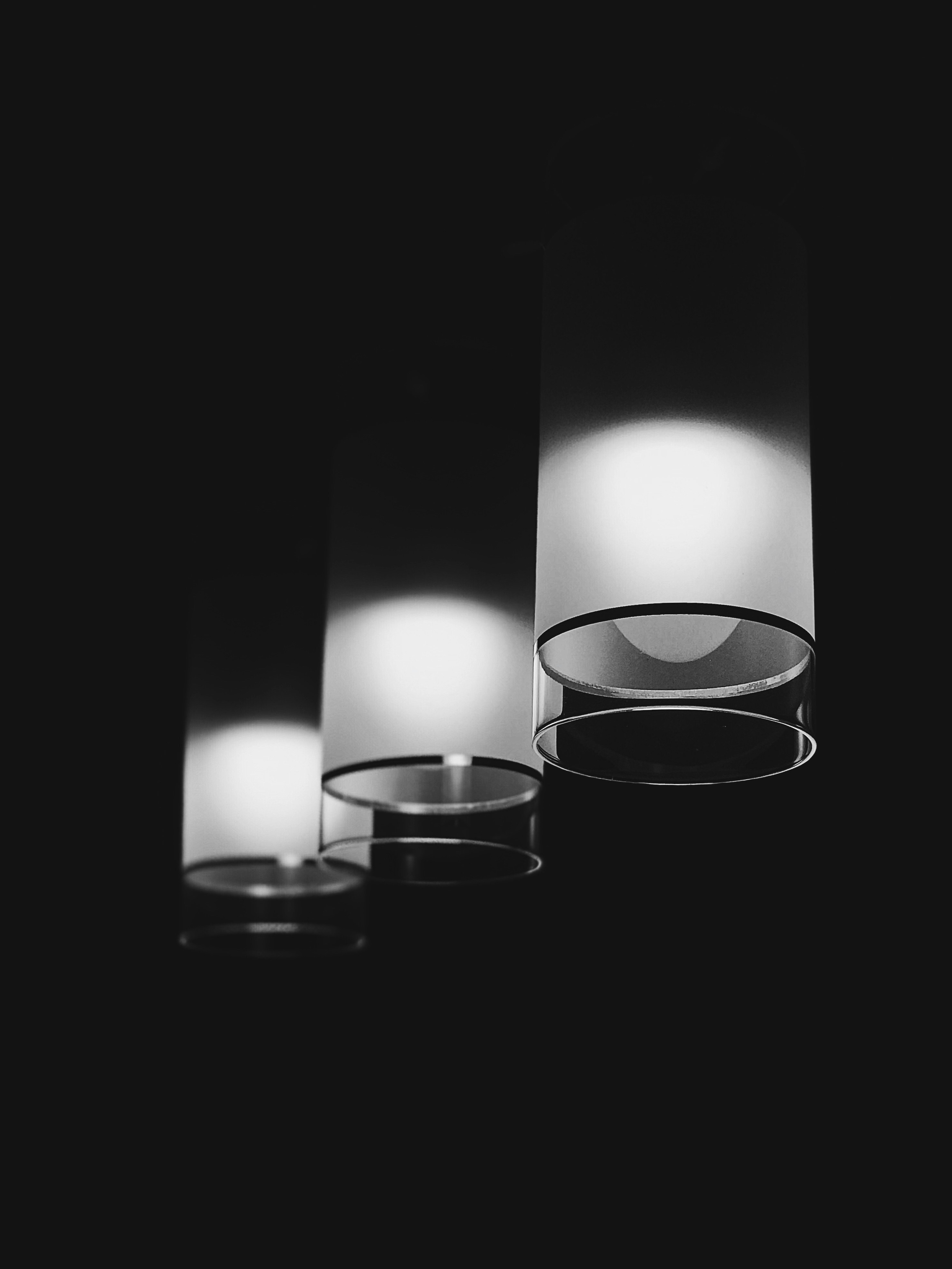 Rising Lanterns: Three Cylindrical Lights Fading into Darkness