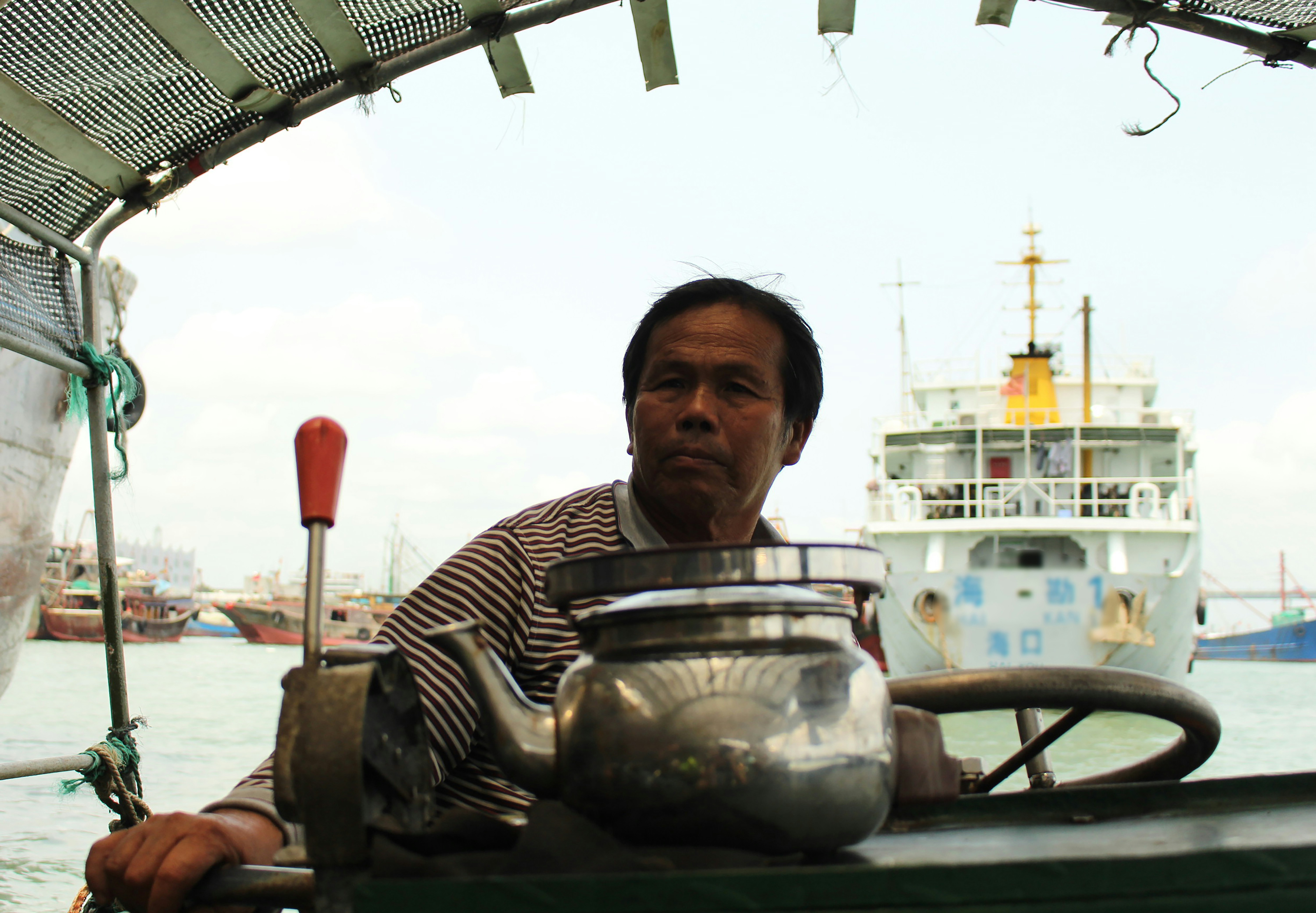 Harbor Portrait with Steam Pot: A Fisherman's Quiet Gaze
