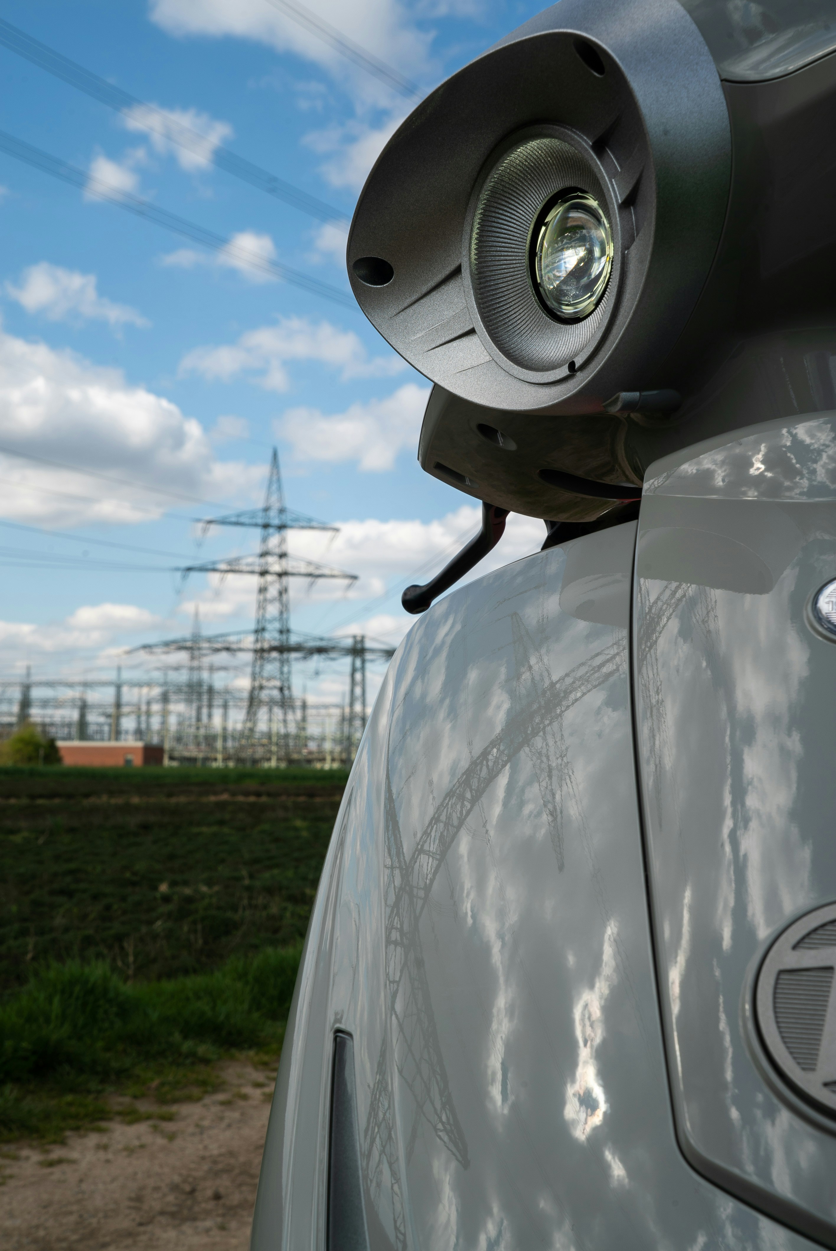 Chrome sentinel on the silver hood: close-up of a dome camera against a sky-filled backdrop