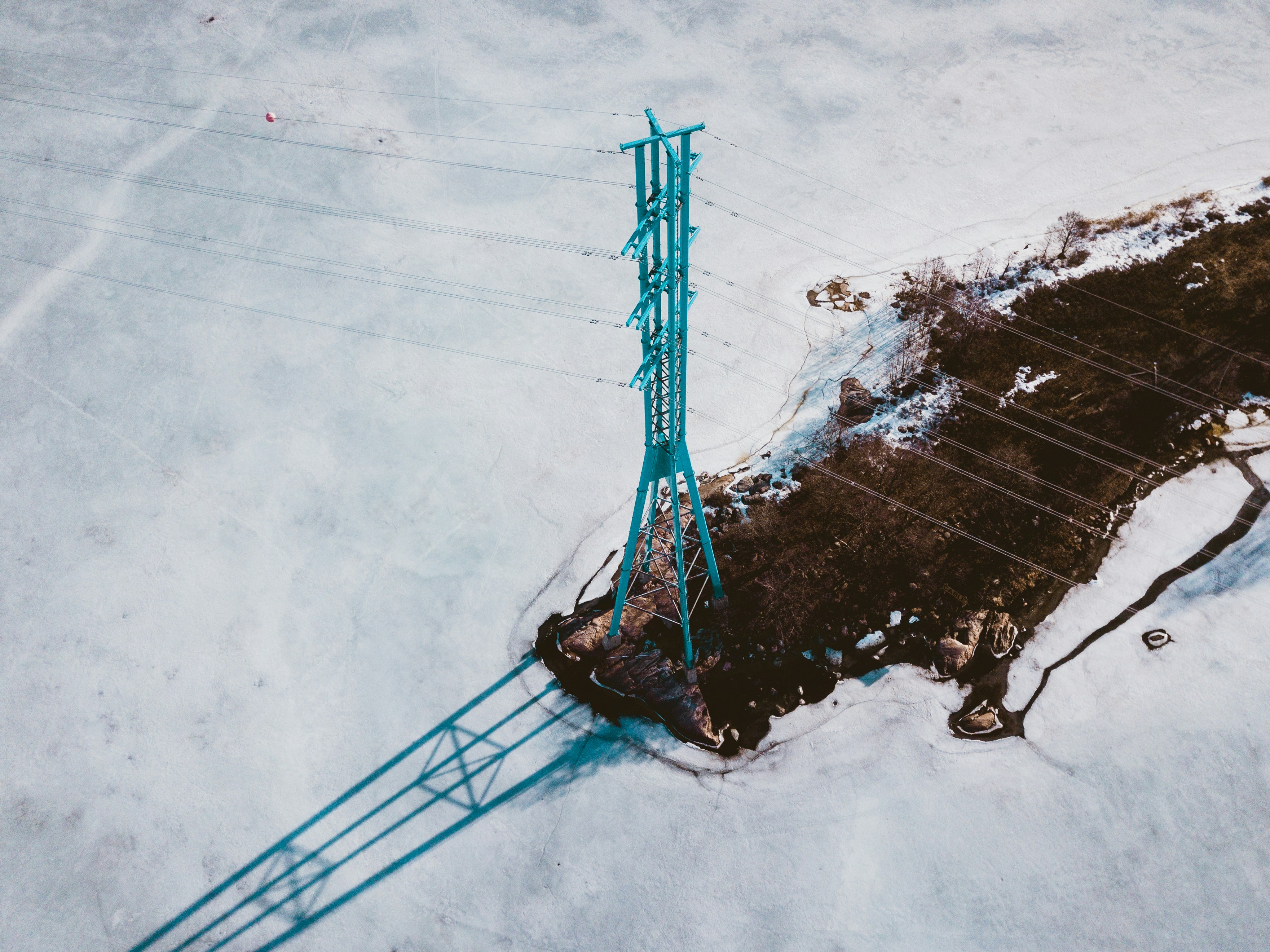 Blue Tower in Snow: Aerial Lines and Long Shadow