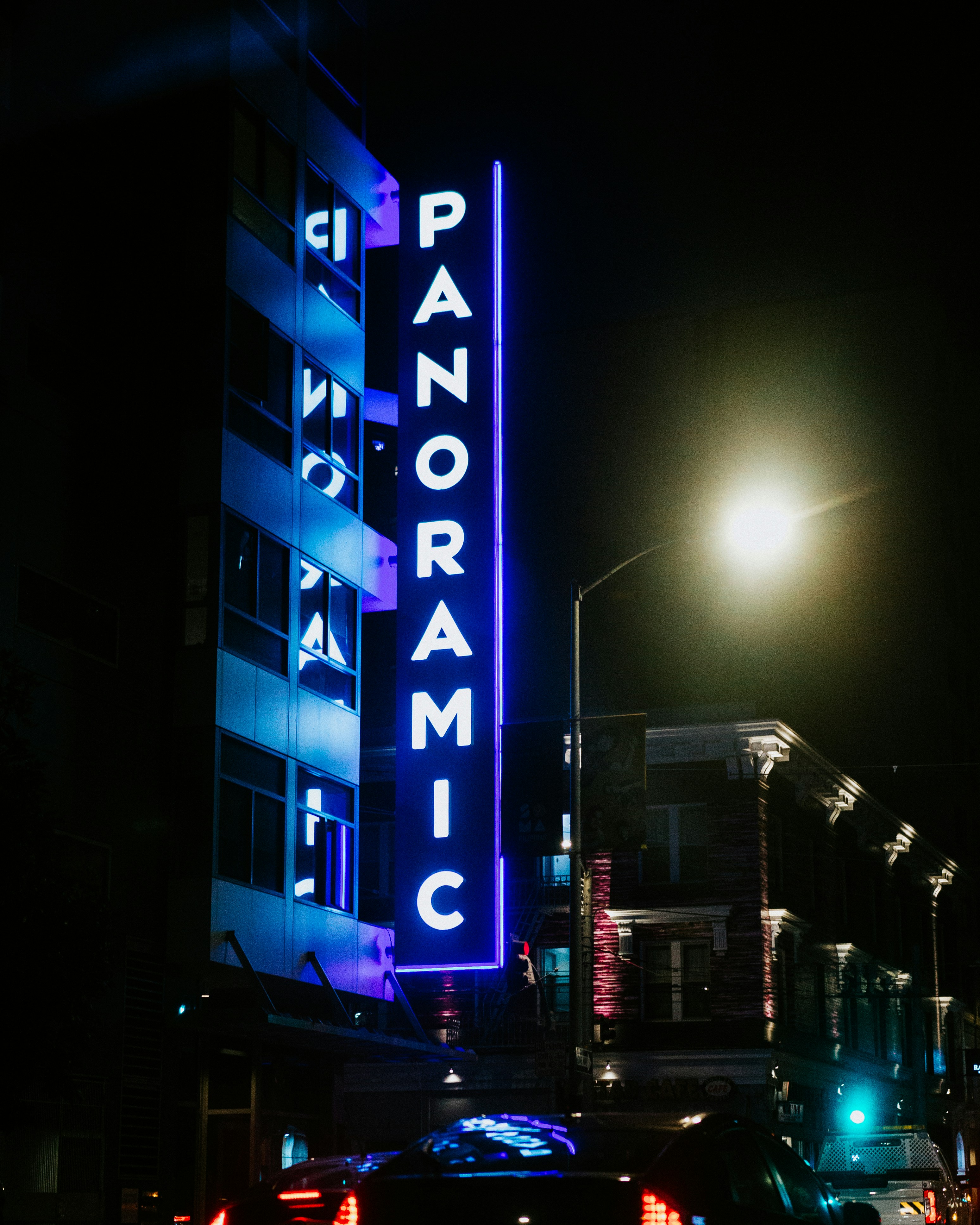 A large neon sign on the side of a building photo – Free Neon Image on ...