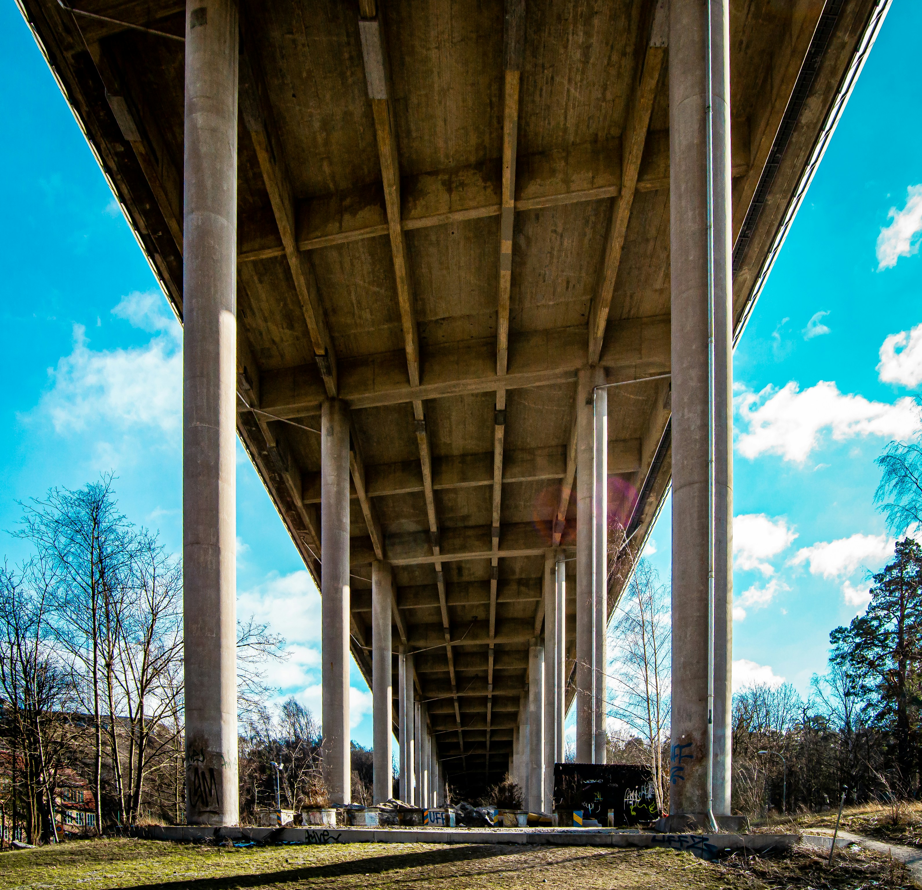 Under Span: Symmetrical Pillars Framing a Sky-Blue Corridor