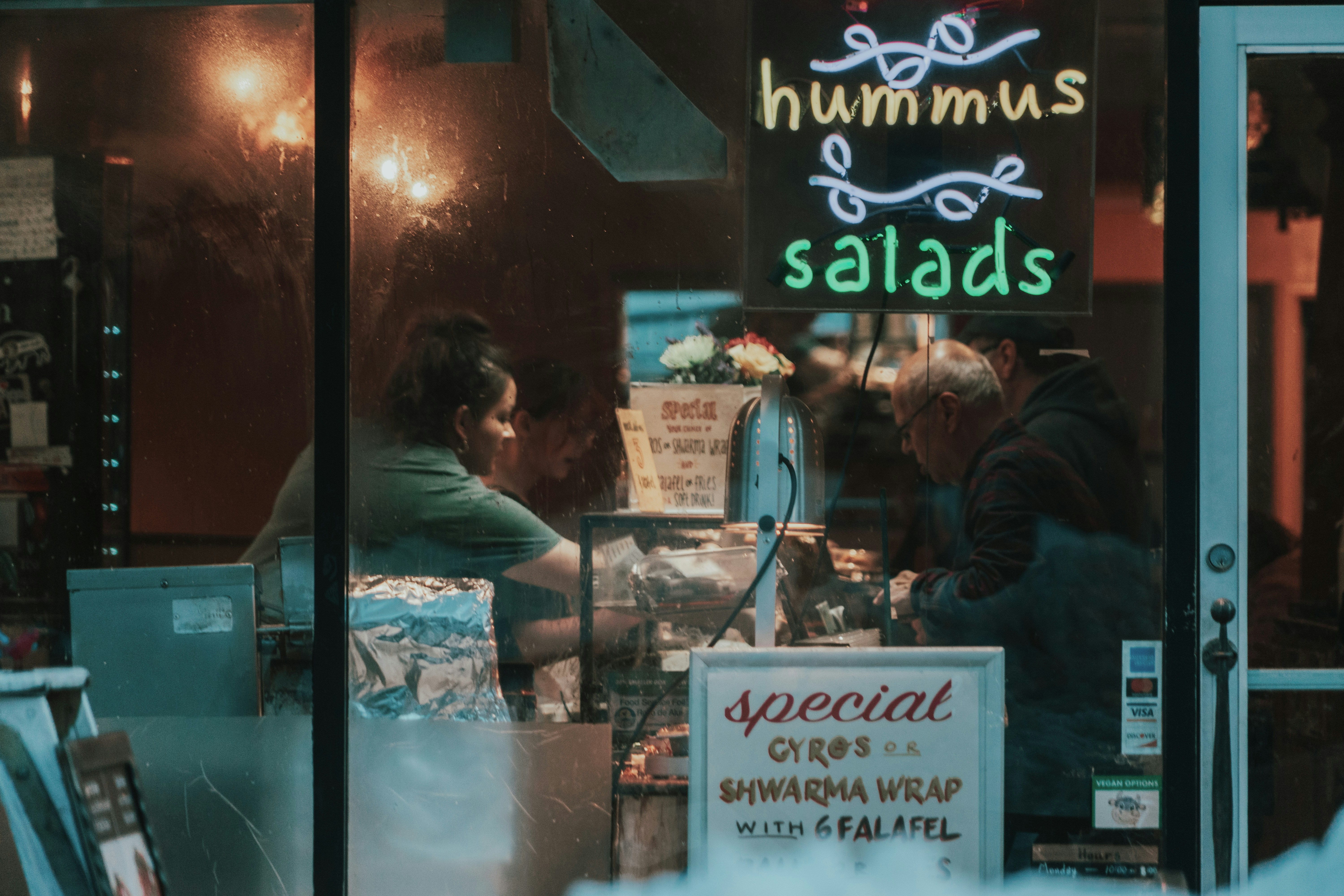 Foto Mujer con chaqueta verde de pie frente al mostrador de vidrio ...