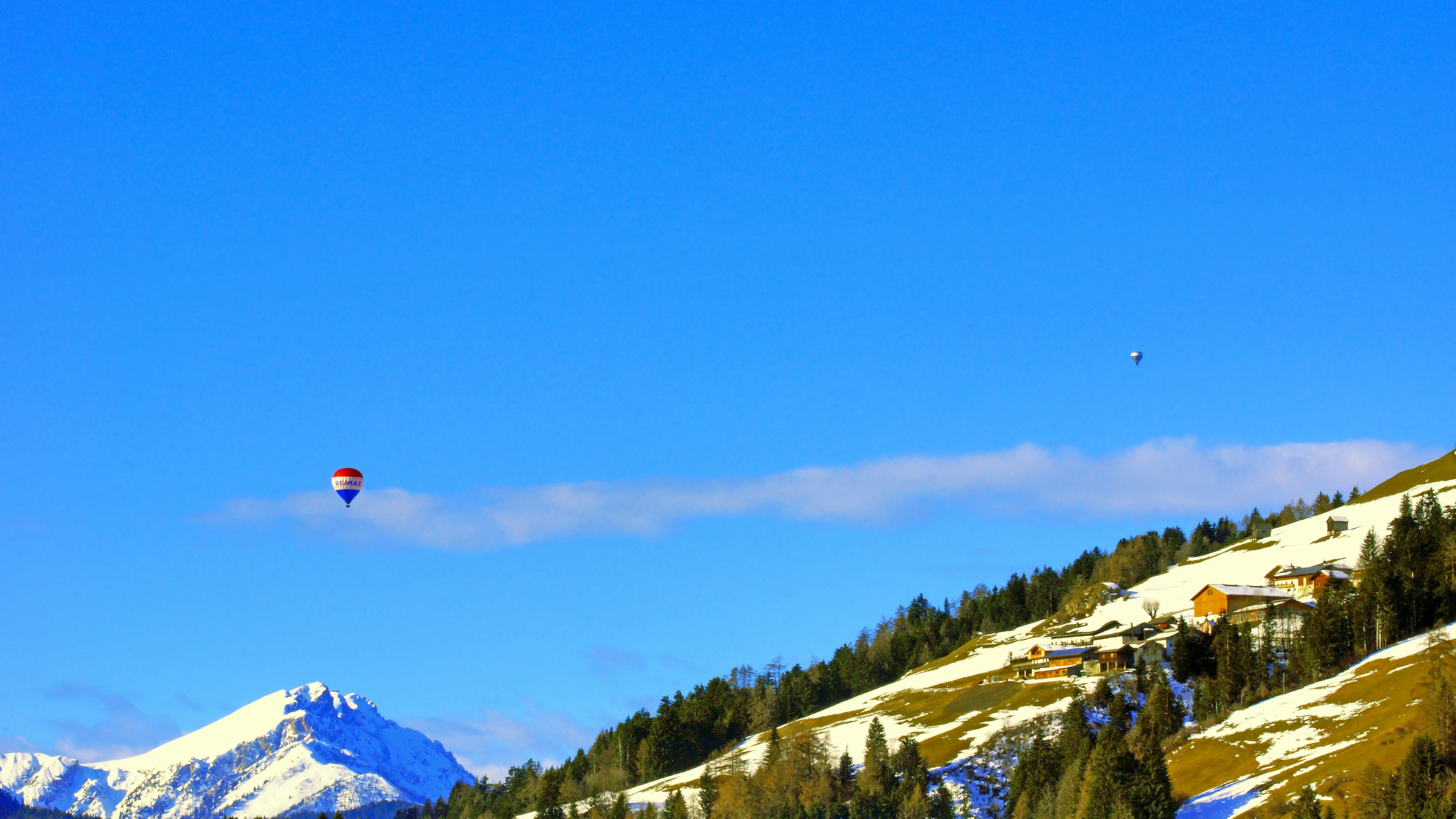 Balloon Drifts Over a Snow-Dusted Alpine Ridge