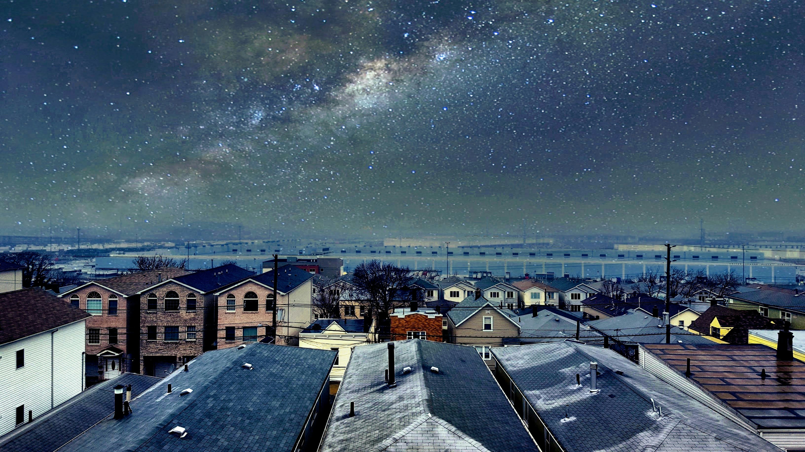 Milky Way Over a Quiet Coastal Town: Rooftops Beneath a Starry Arc