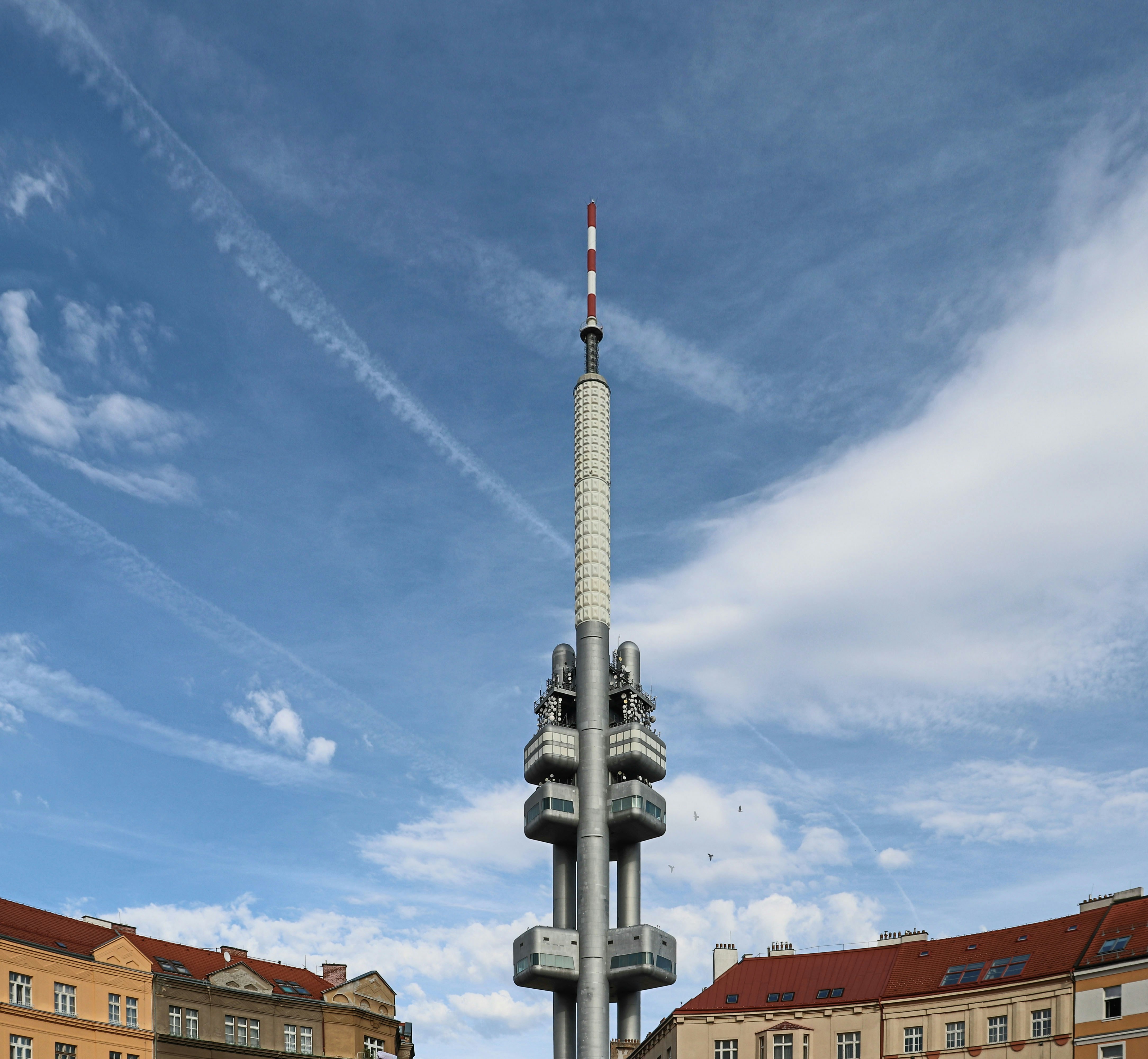 Central Spire Over Red Roofs: An Urban Tower Reaches Toward a Bright Sky