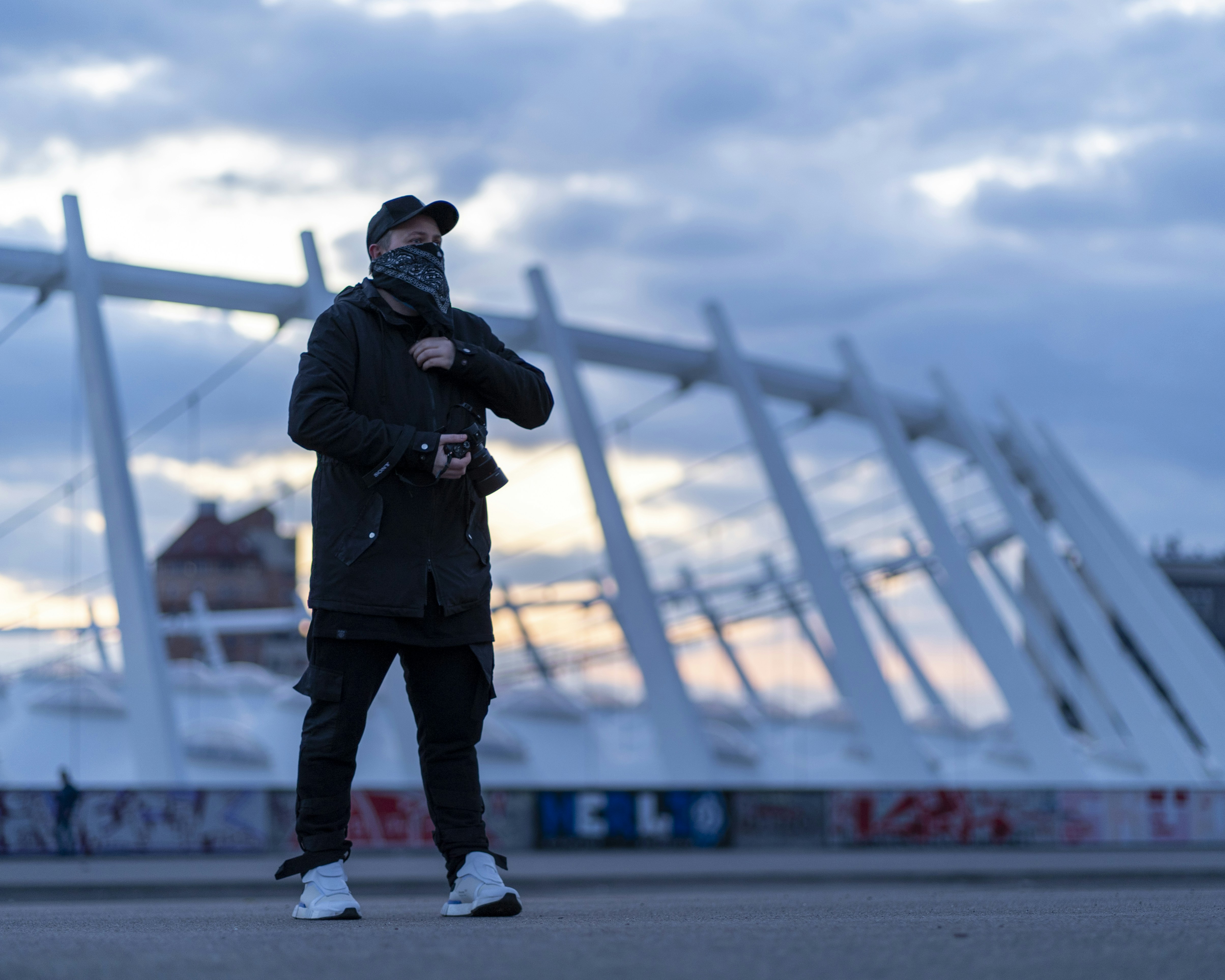 Masked wanderer on a sunlit pier: silhouettes and steel ribs