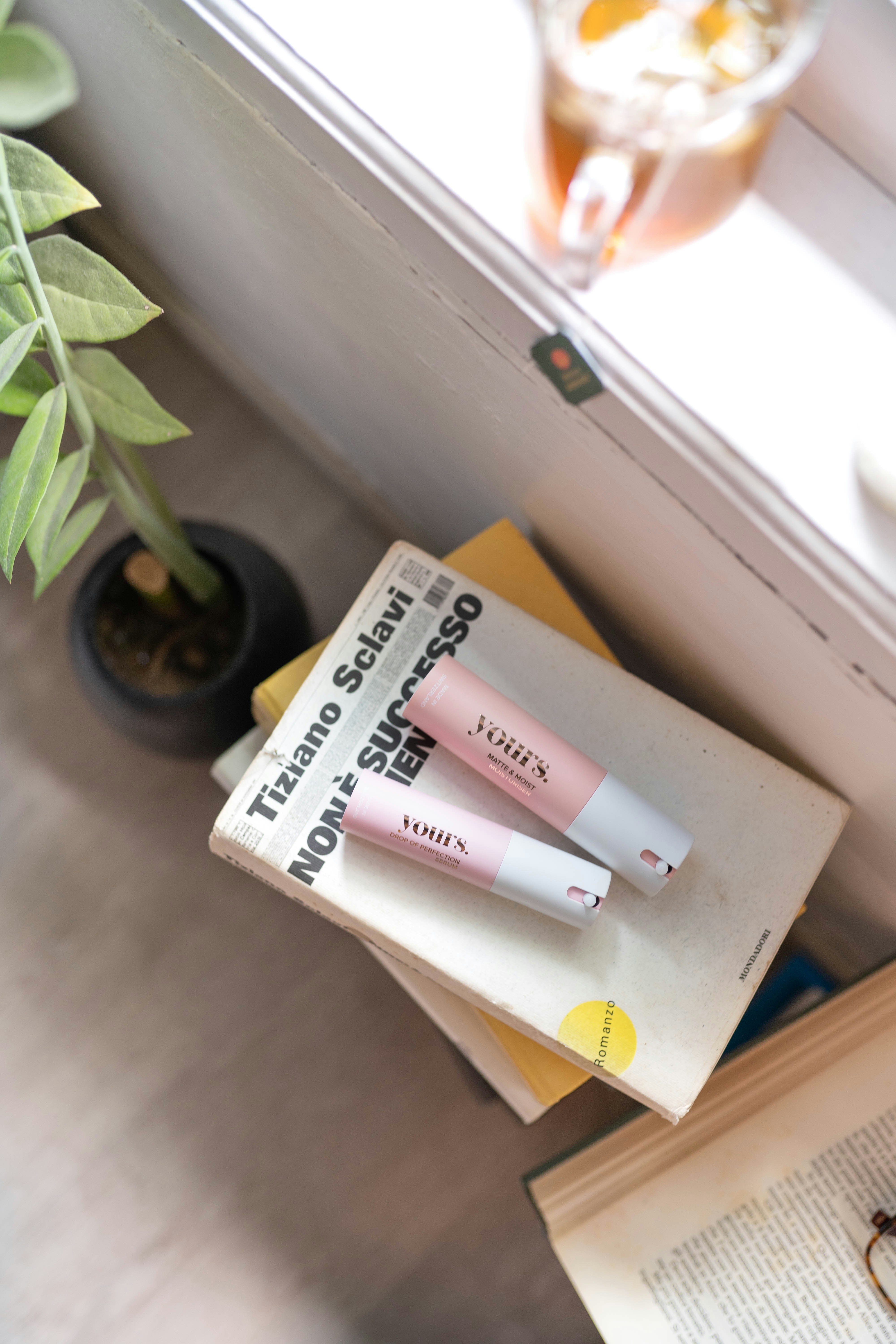 Pastel Lip Balms on a Window-Sill Stack of Books