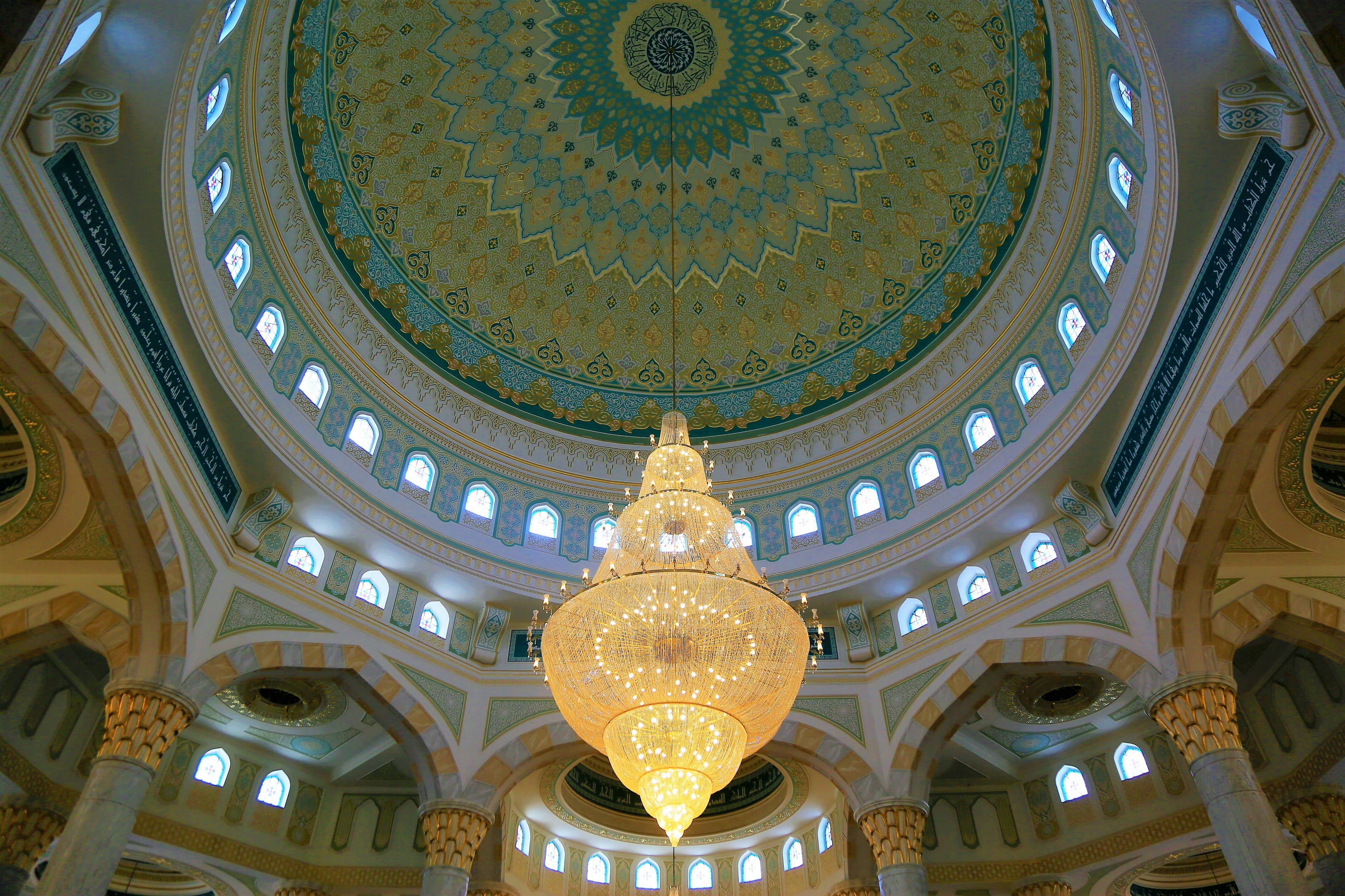 Intricate dome pattern with a grand chandelier in an ornate interior setting.