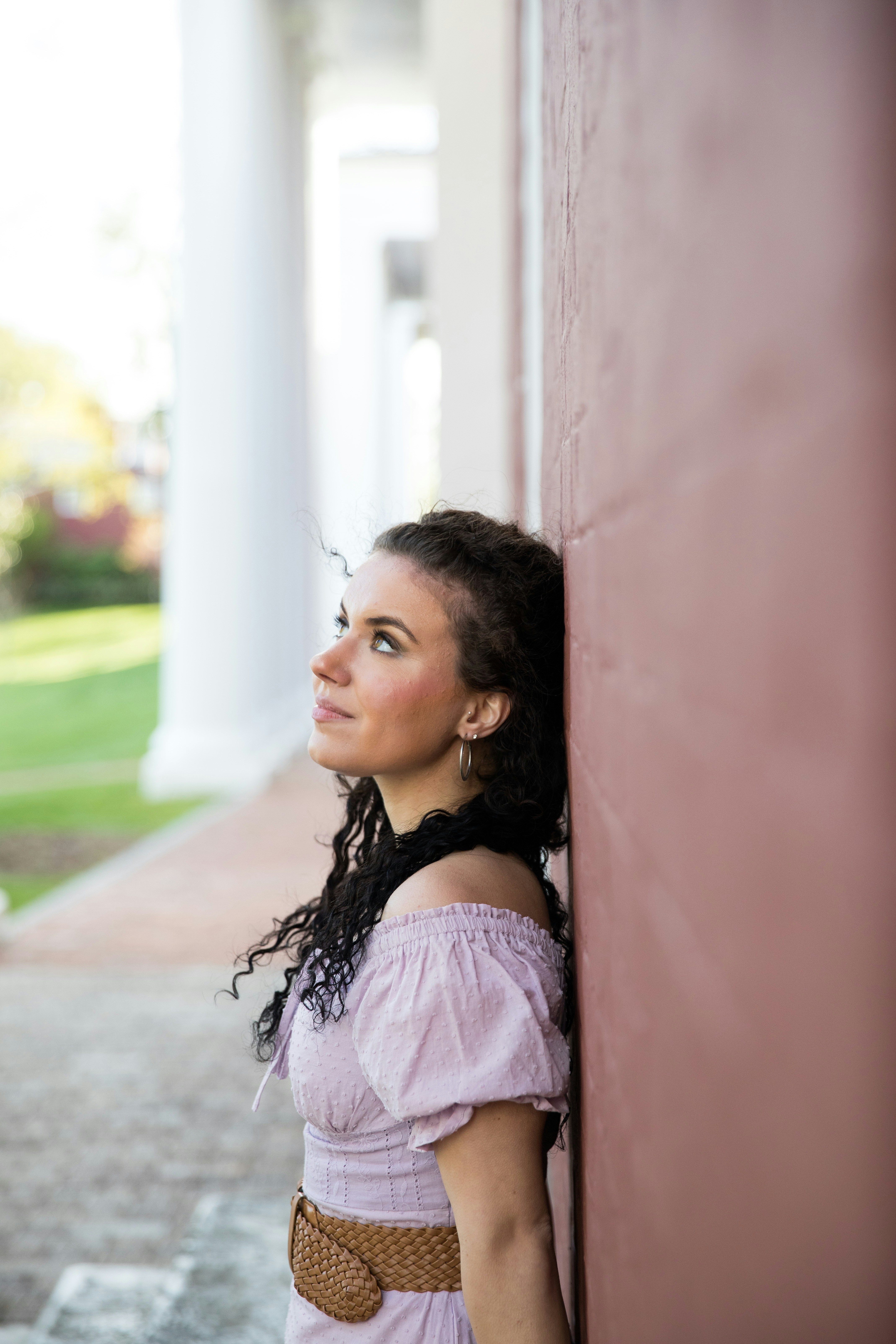 Girl in white and pink tank top leaning on red wall during daytime ...