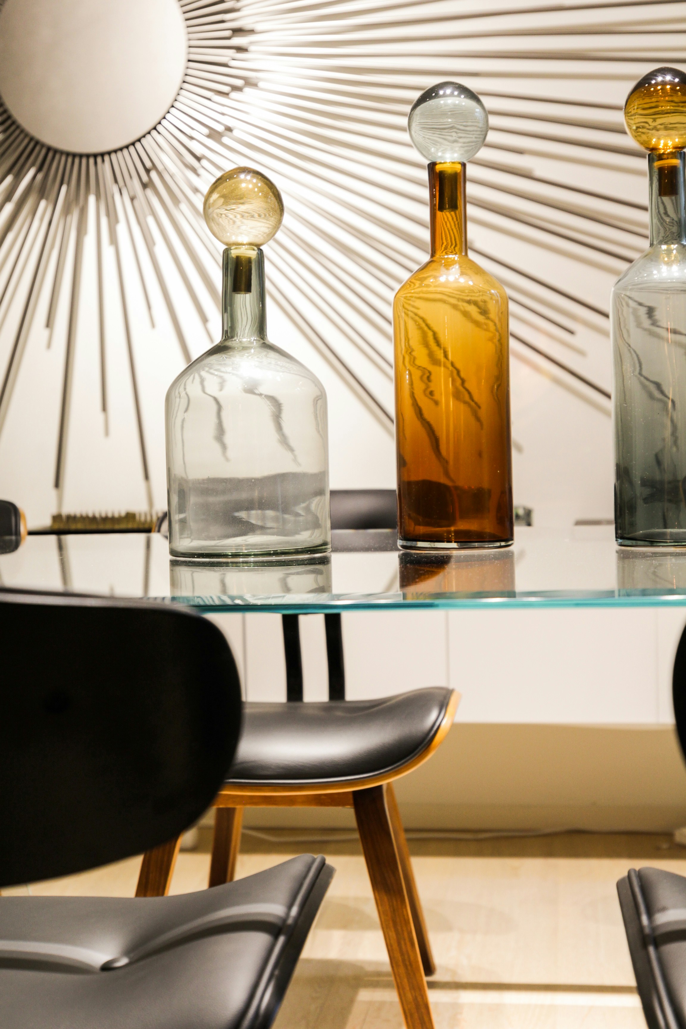 Glass Bottles on a Glass Table Under a Radiating Sunburst