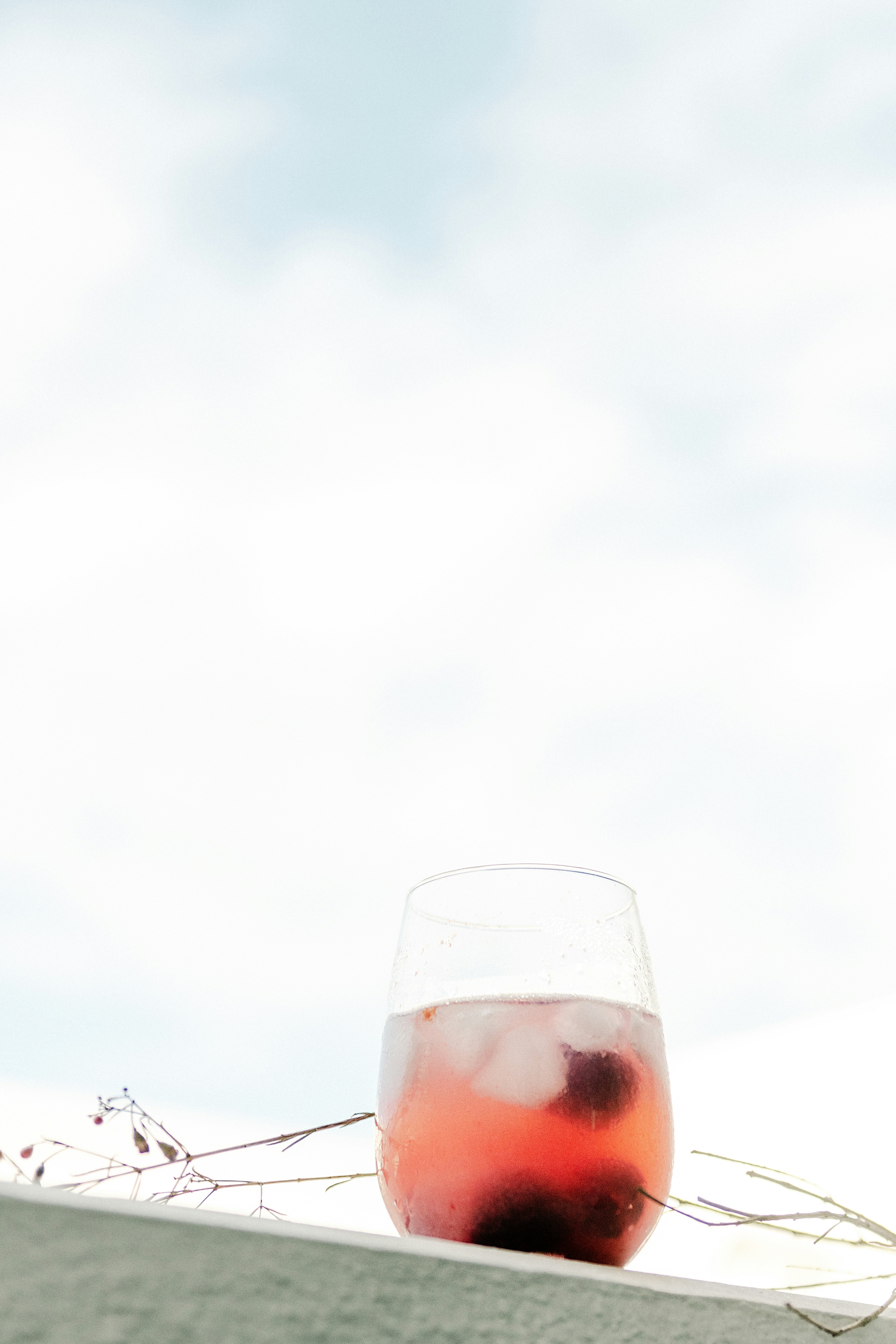 Sunlit Sip: A Glass of Rosé Resting on a Quiet Rooftop Edge