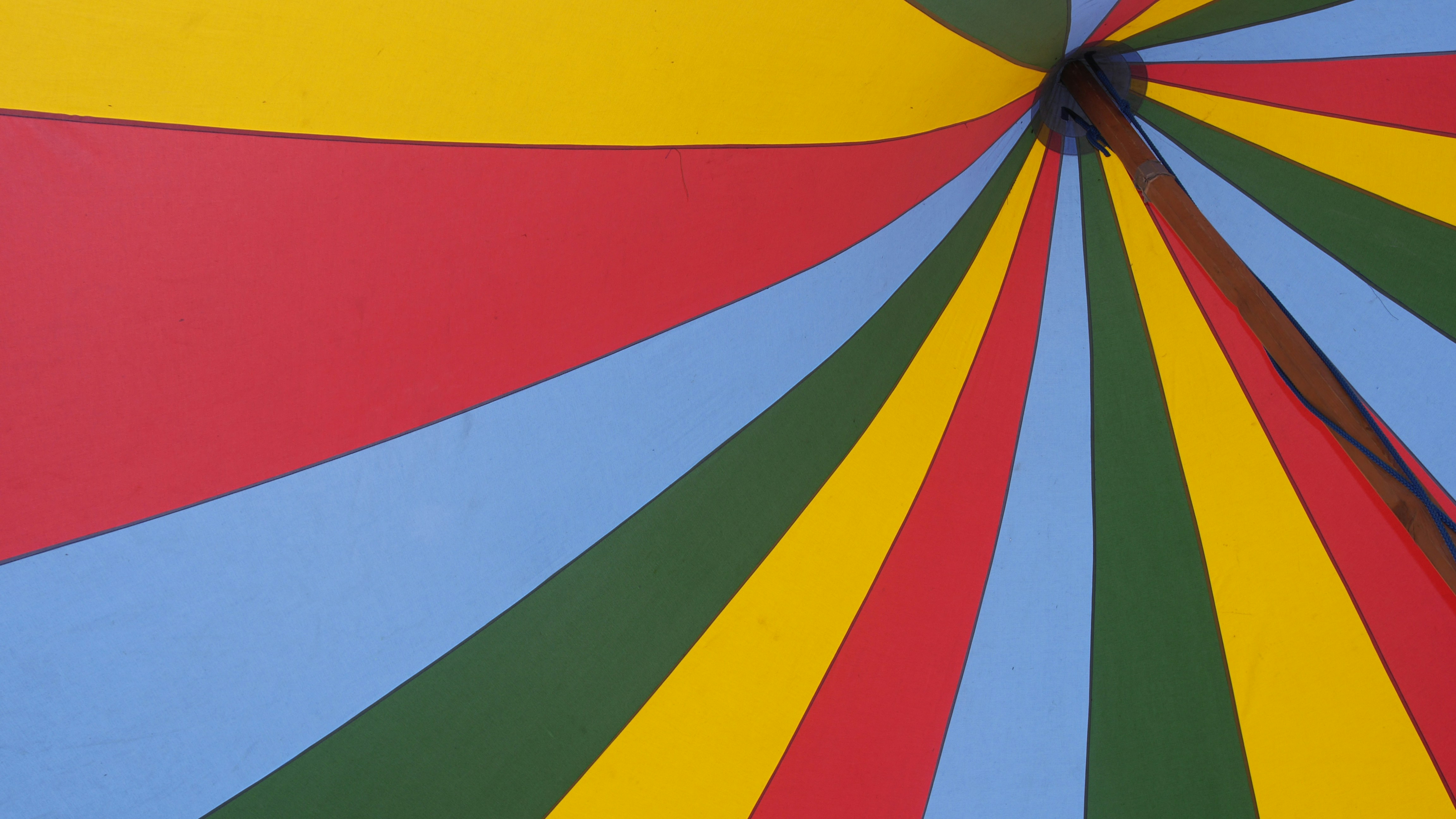 Colorful striped fabric creating a dynamic pattern overhead in a festive setting.