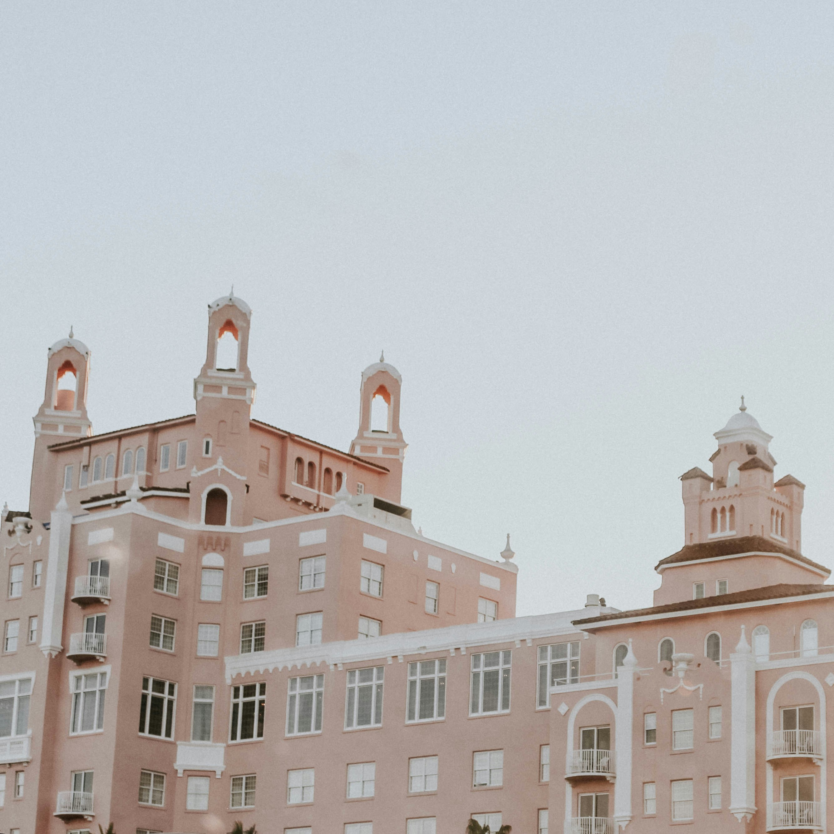Pastel-Pink Towers Rise Over a Quiet Campus Façade