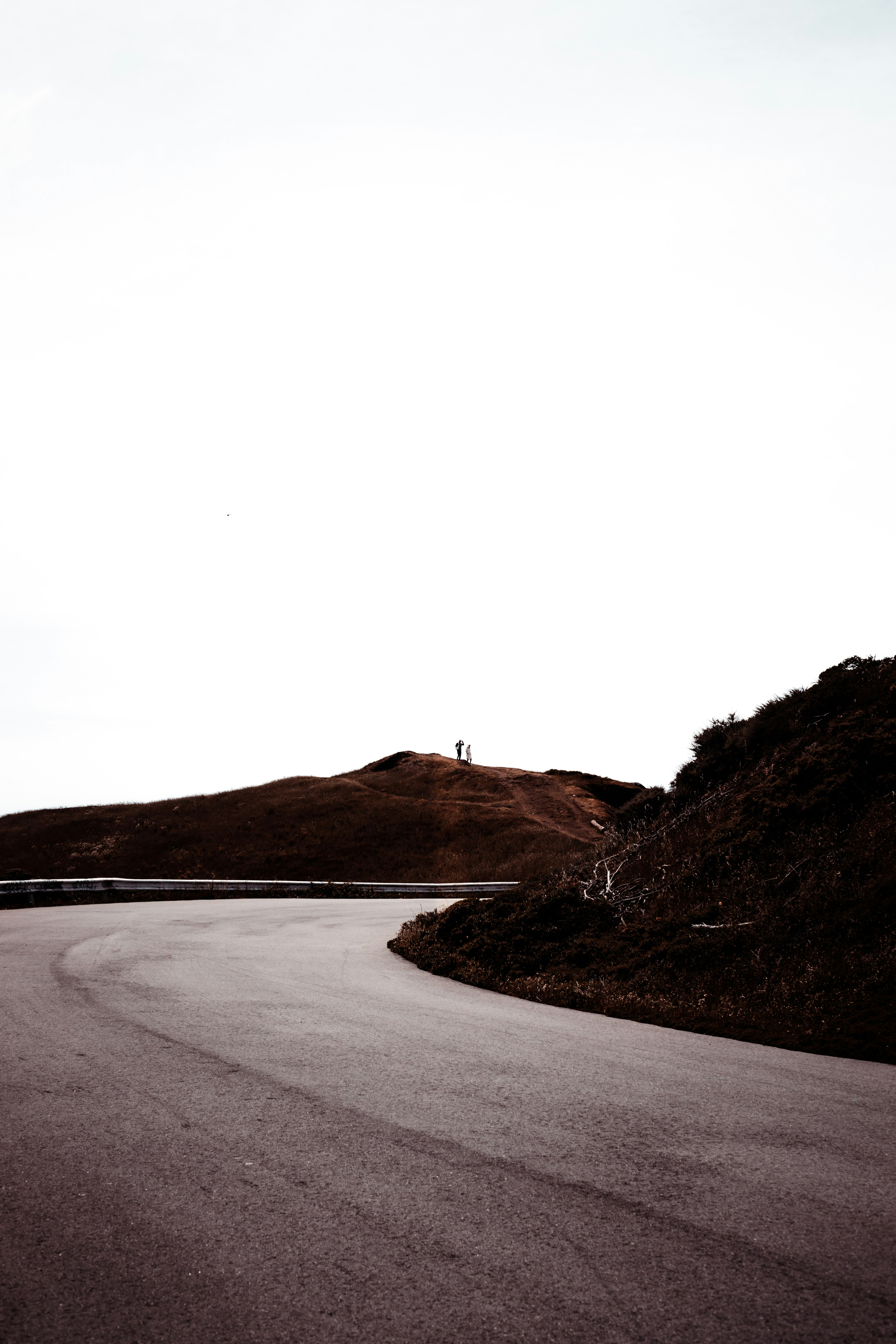 gray asphalt road near body of water during daytime