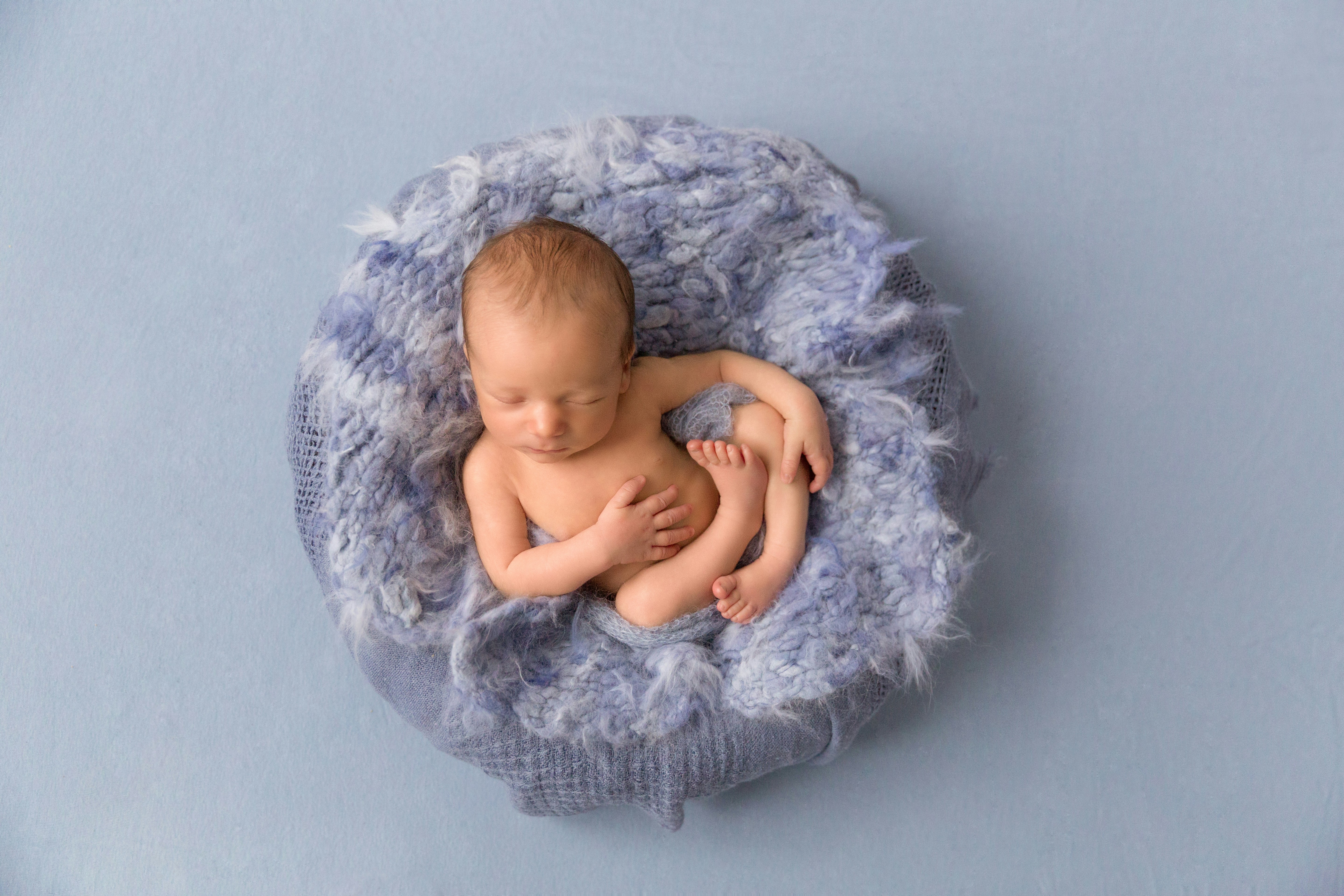 Centered cradle: a newborn nestled in a soft blue nest