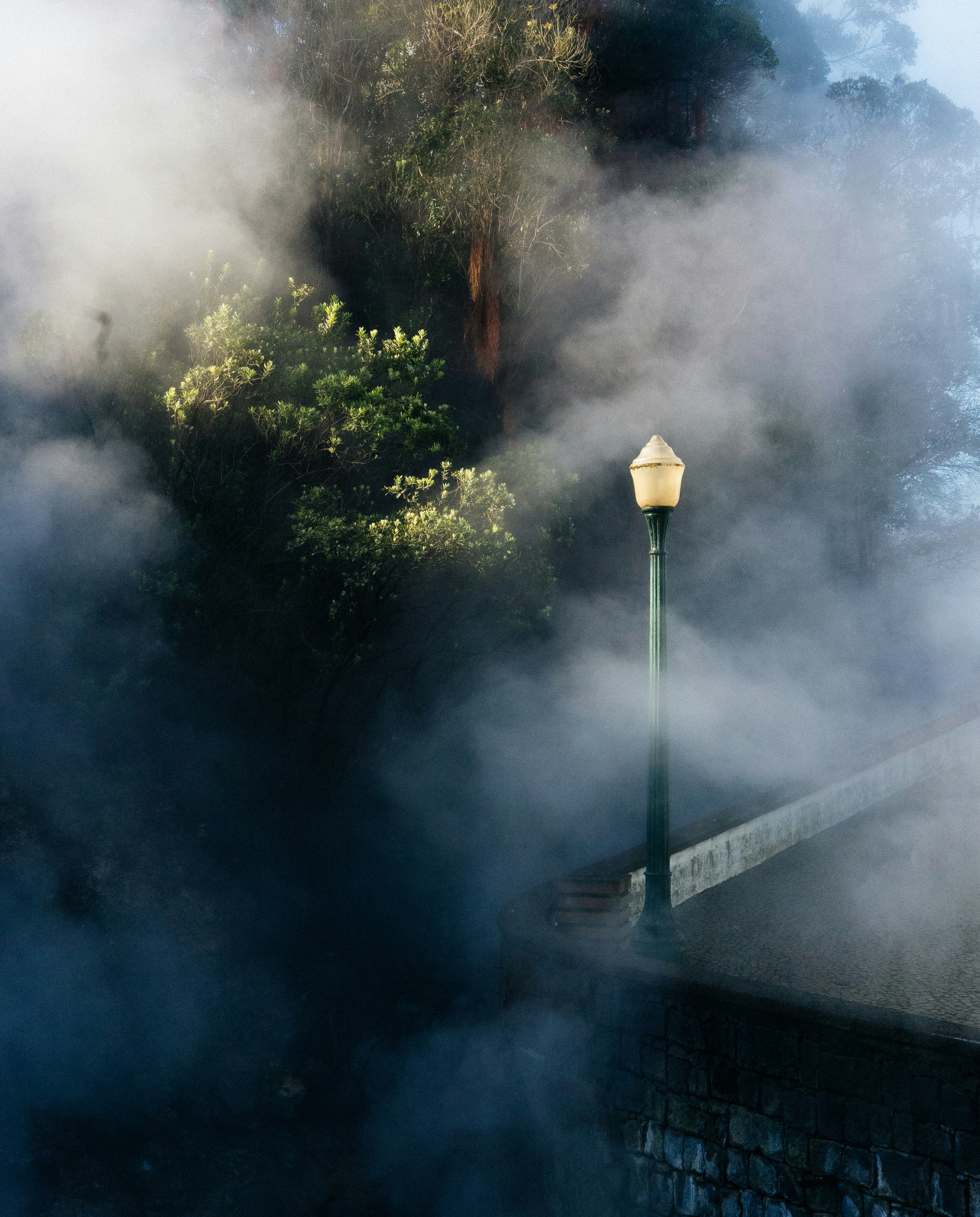 Fog-Shrouded Lantern Over a Quiet Riverside Bridge