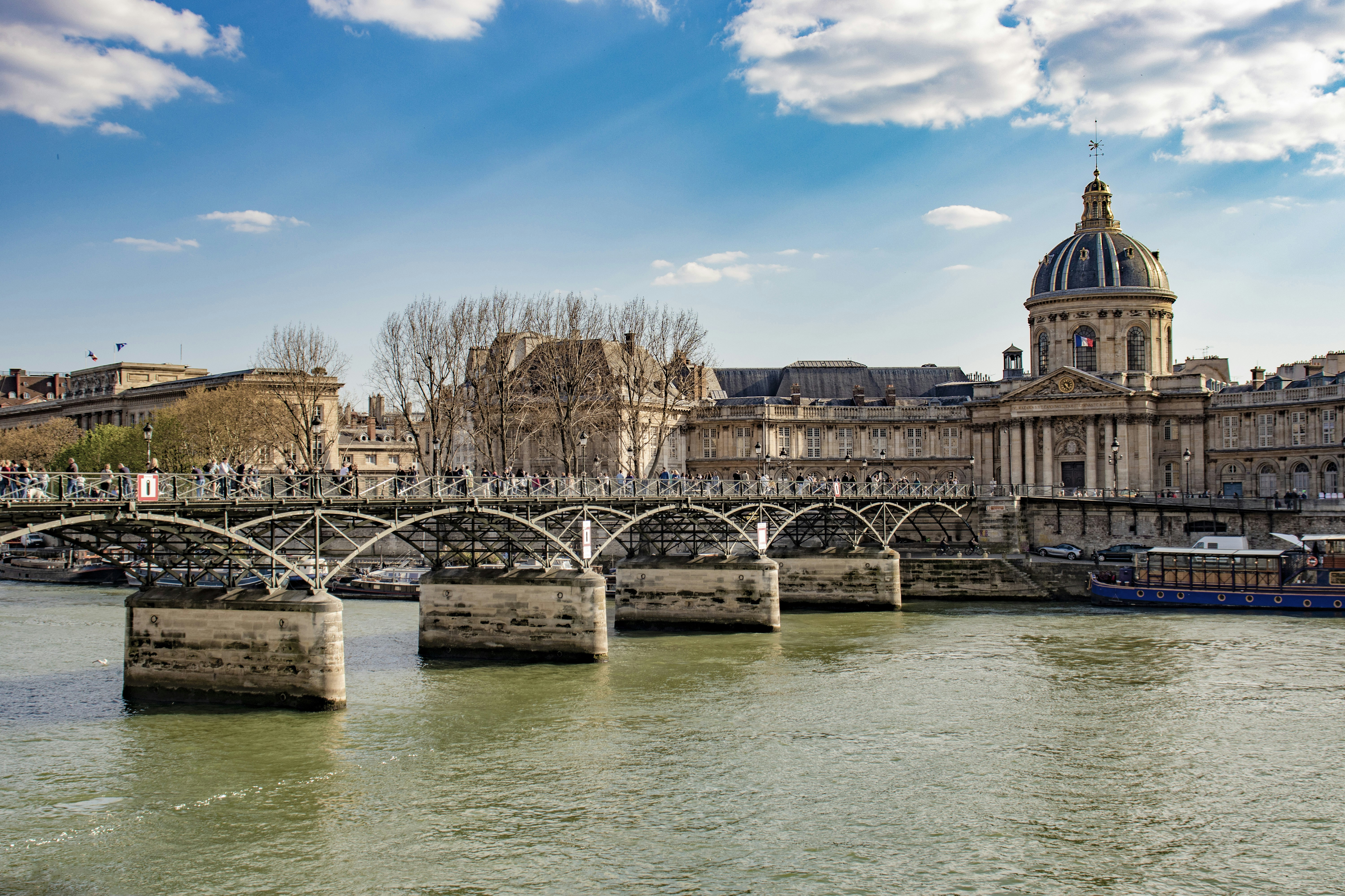 Brown concrete building near bridge and river under blue sky during ...